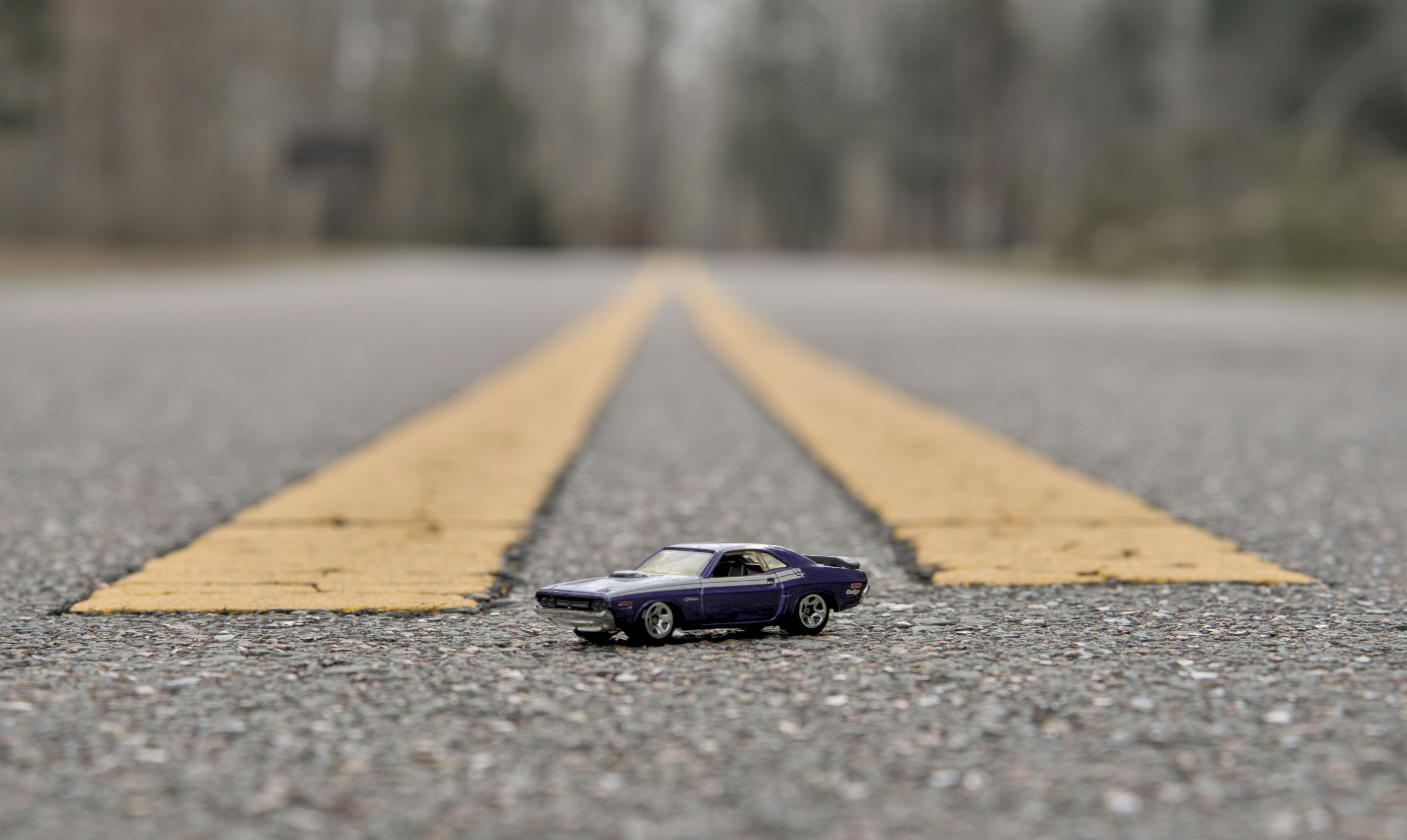 Tiny Car, Big Road: A Lone Toy Vehicle on a Looming Highway