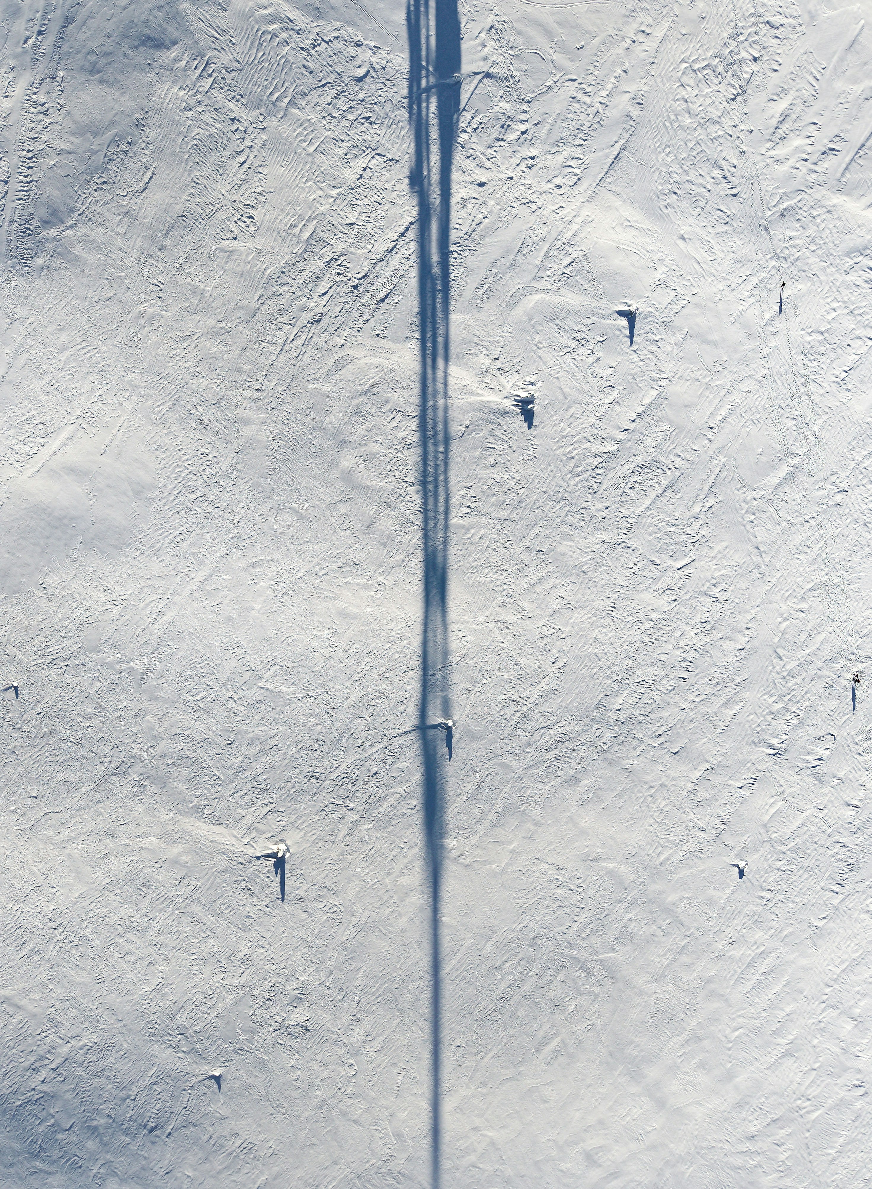 Shadowed Shroud: A Central Cable Cutting Through Snow