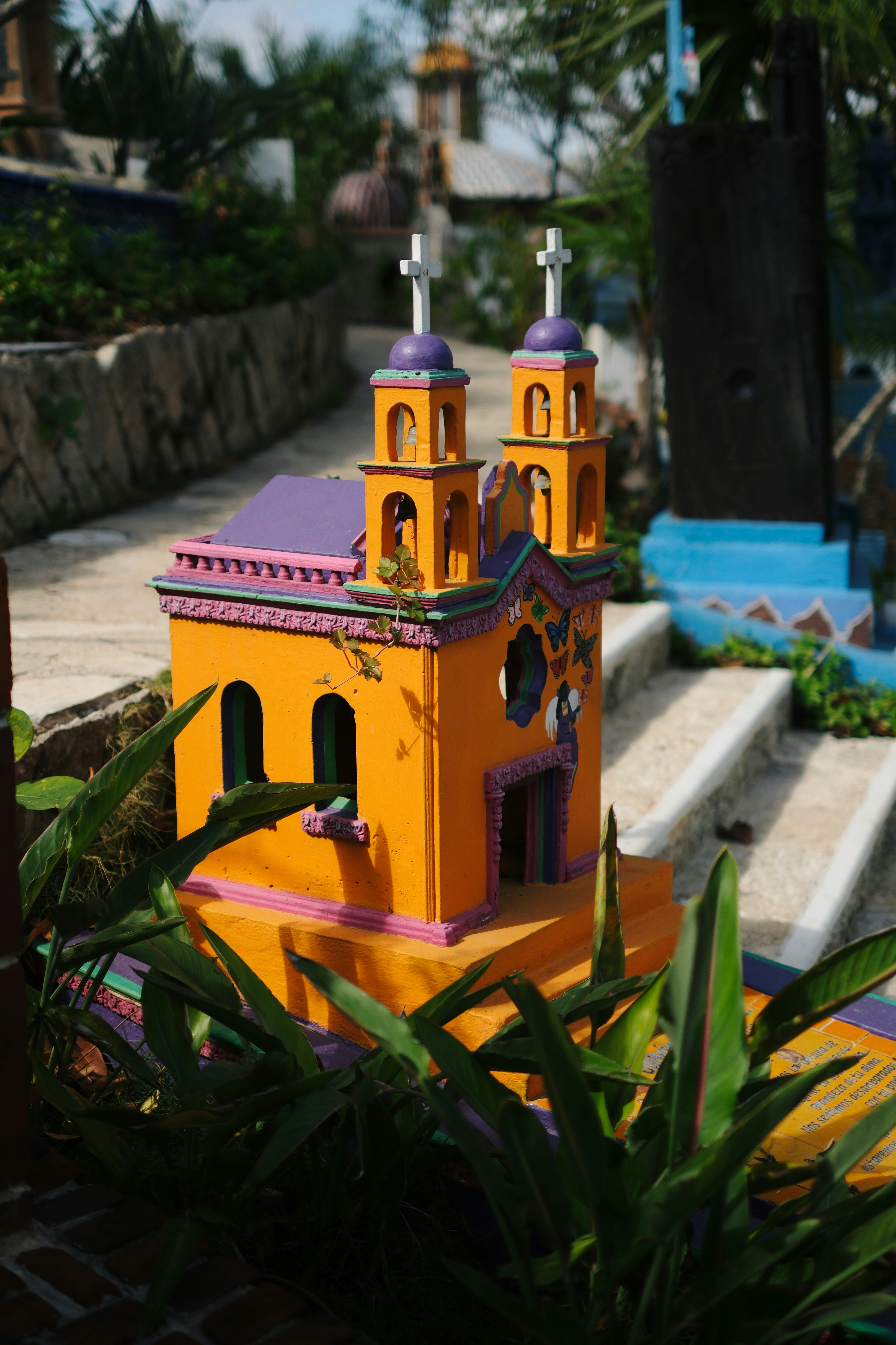 Vibrant miniature temple rising from garden foliage