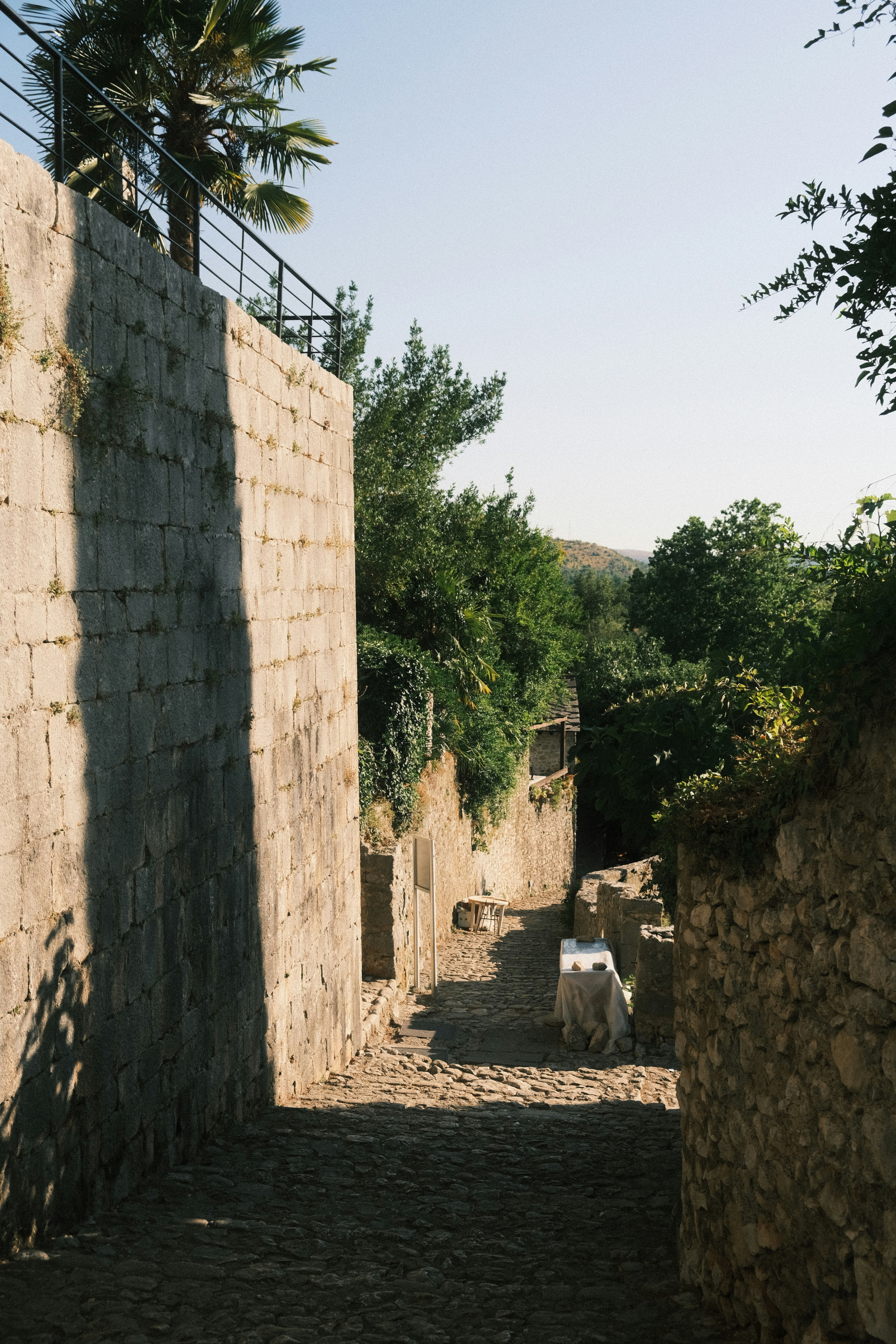 Stone-walled alleyway bathed in late afternoon light