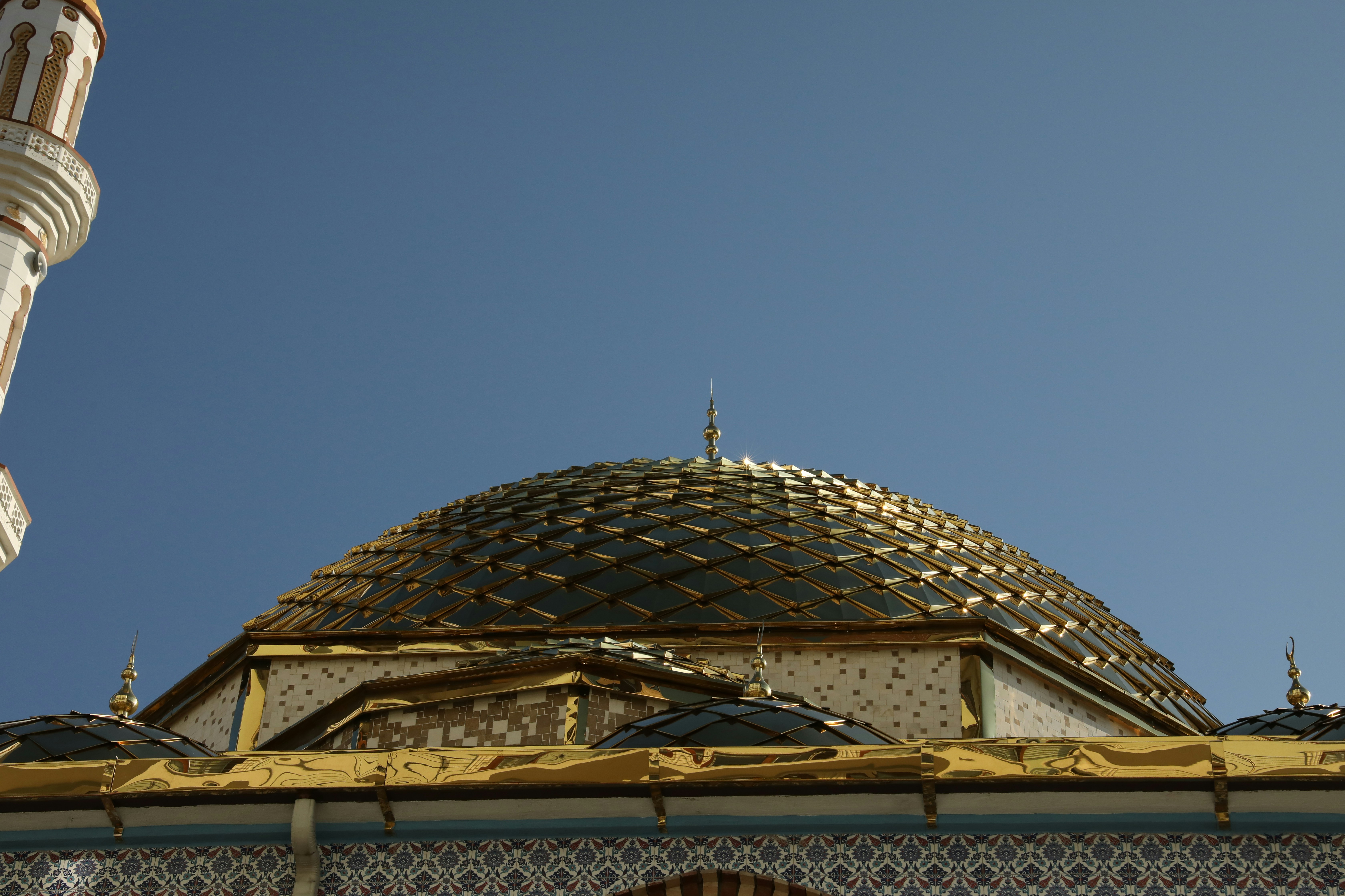 Copper-Tiled Dome of a Historic Mosque Blooming Under Clear Sky