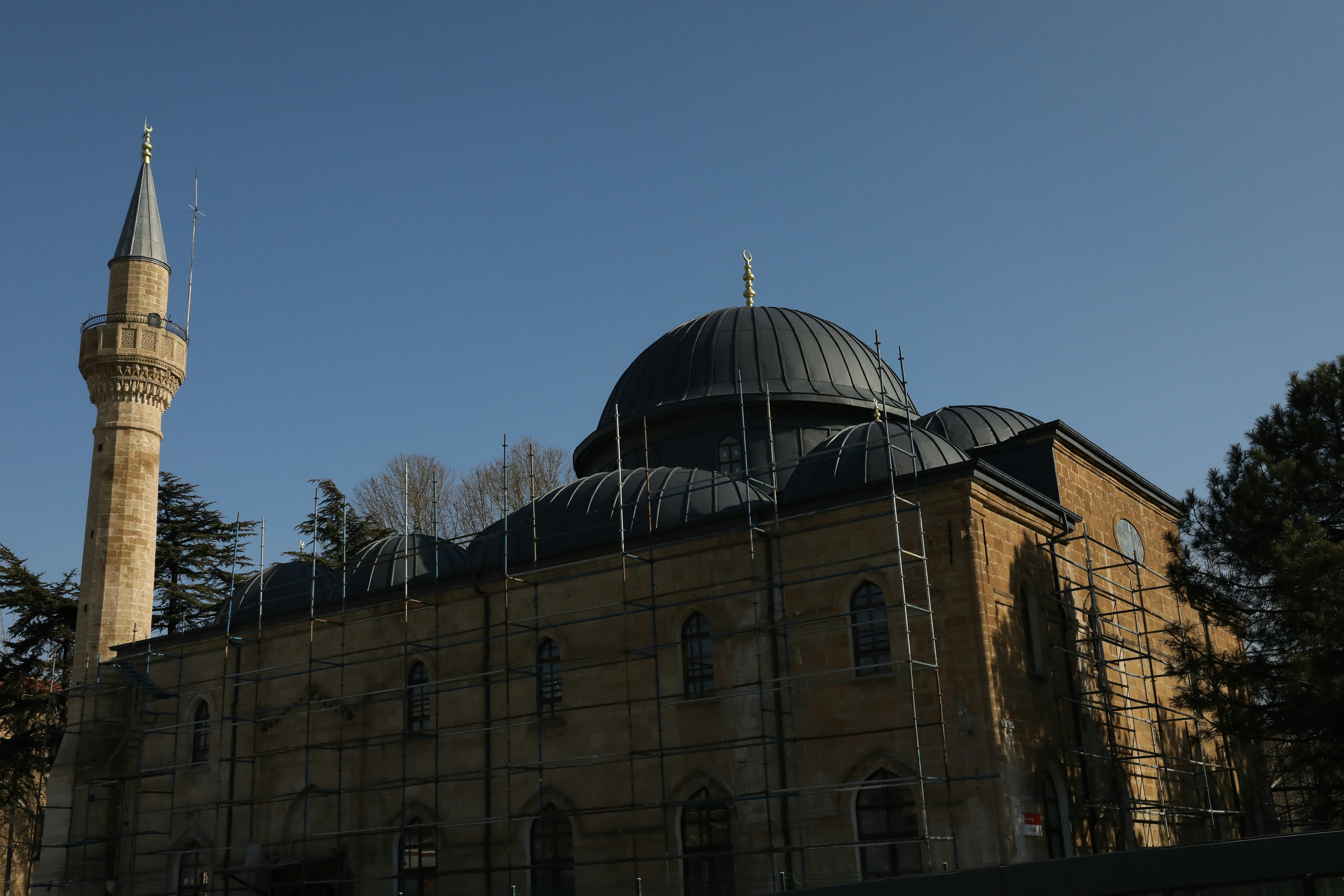 Scaffolded Mosque: Dome, Minaret, and Skyline in the Late Afternoon