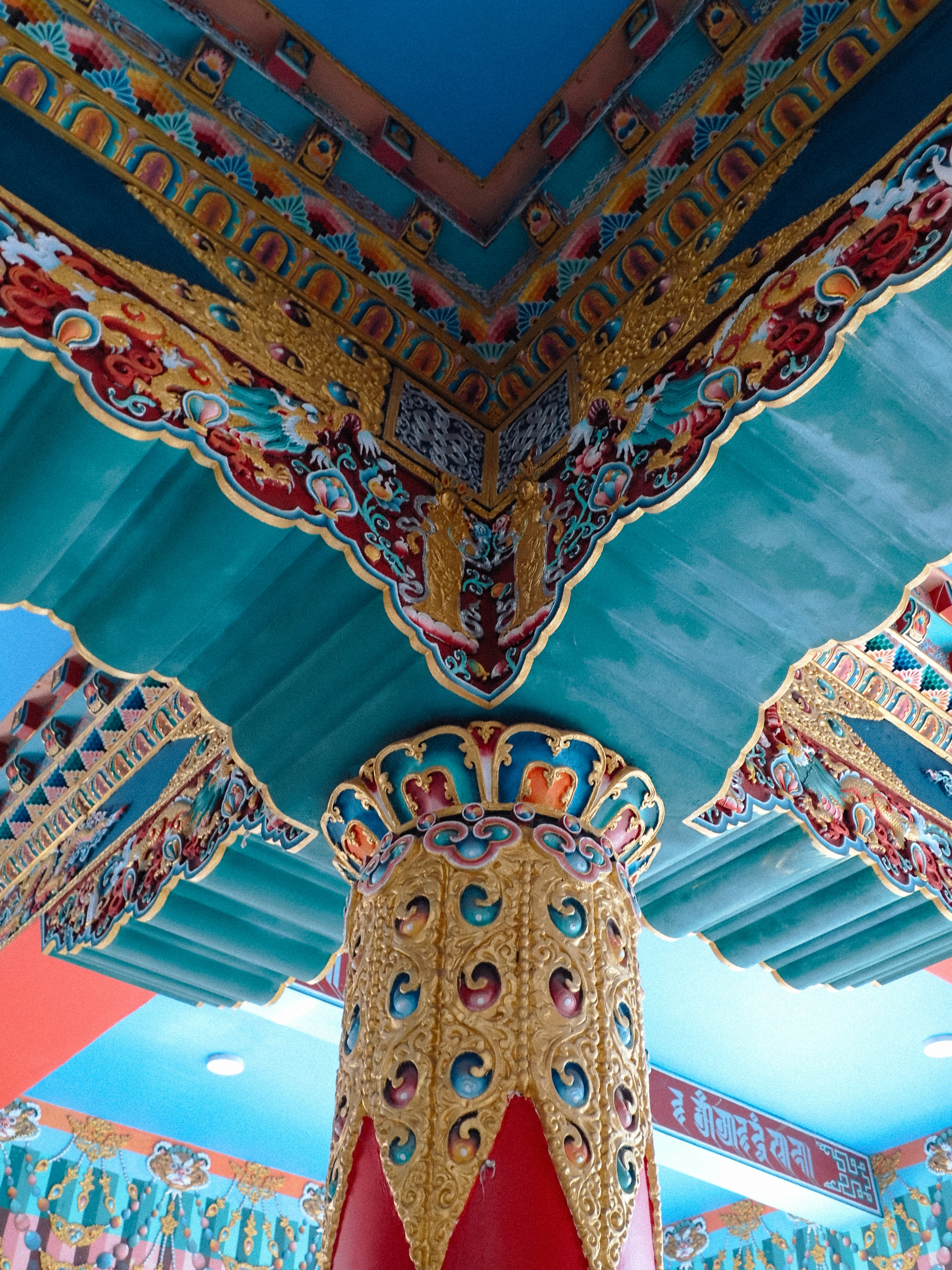 Ornate column and ceiling details in a colorful temple
