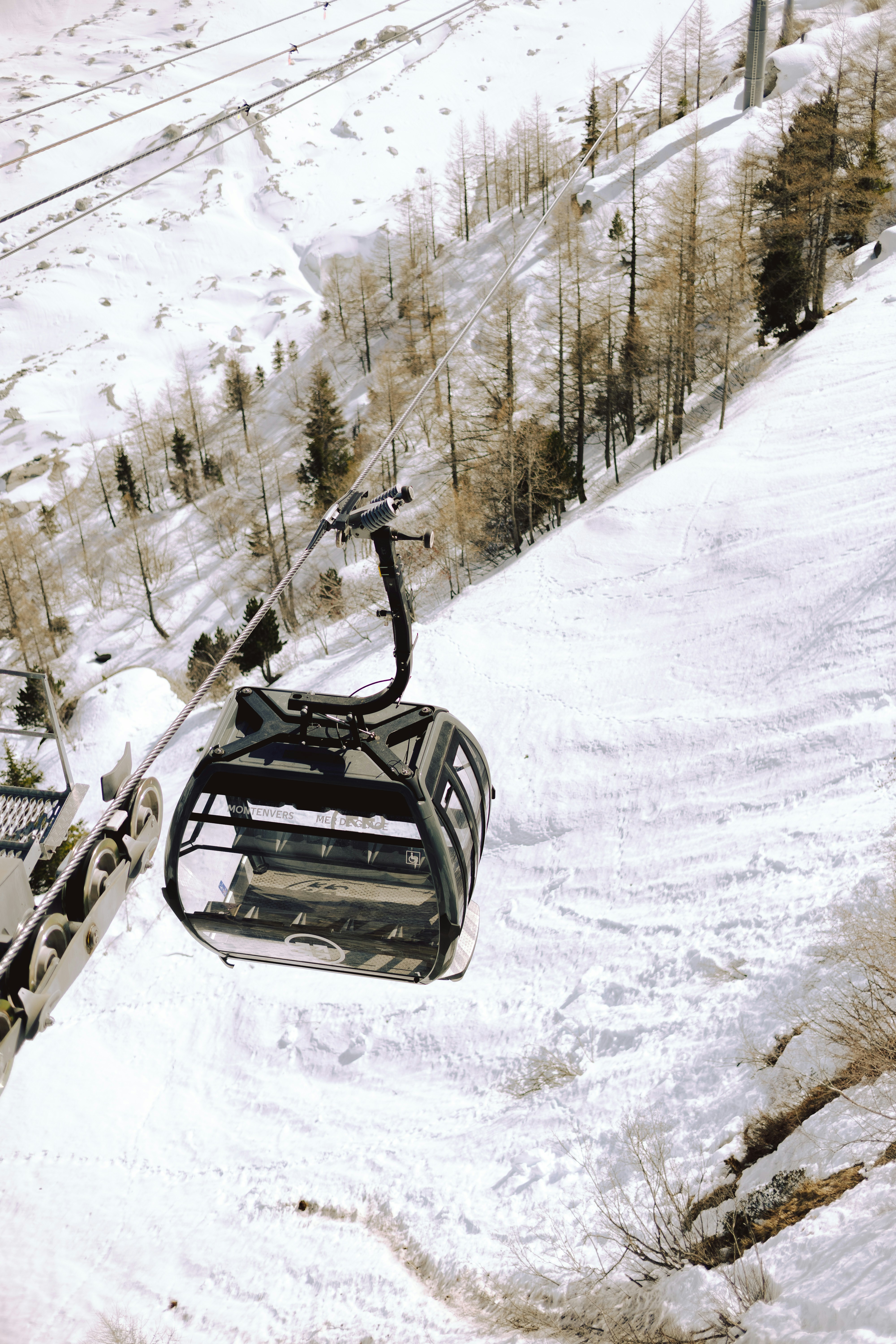 Lift Cable Descent: Gondola Car Sweeps Over Snowy Valleys