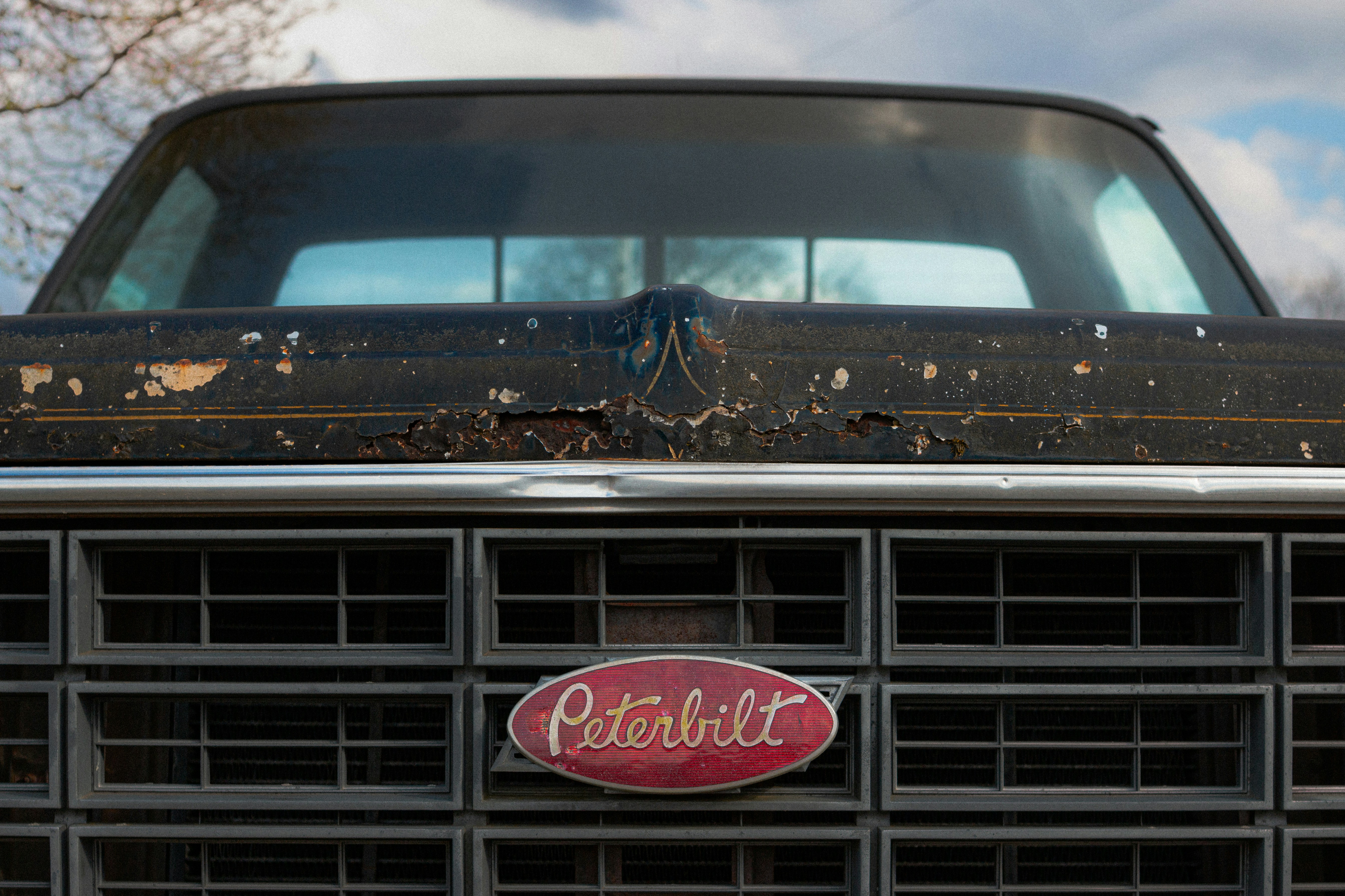 Rusty Peterbilt Crest: A Weathered Front Grille with a Faded Emblem