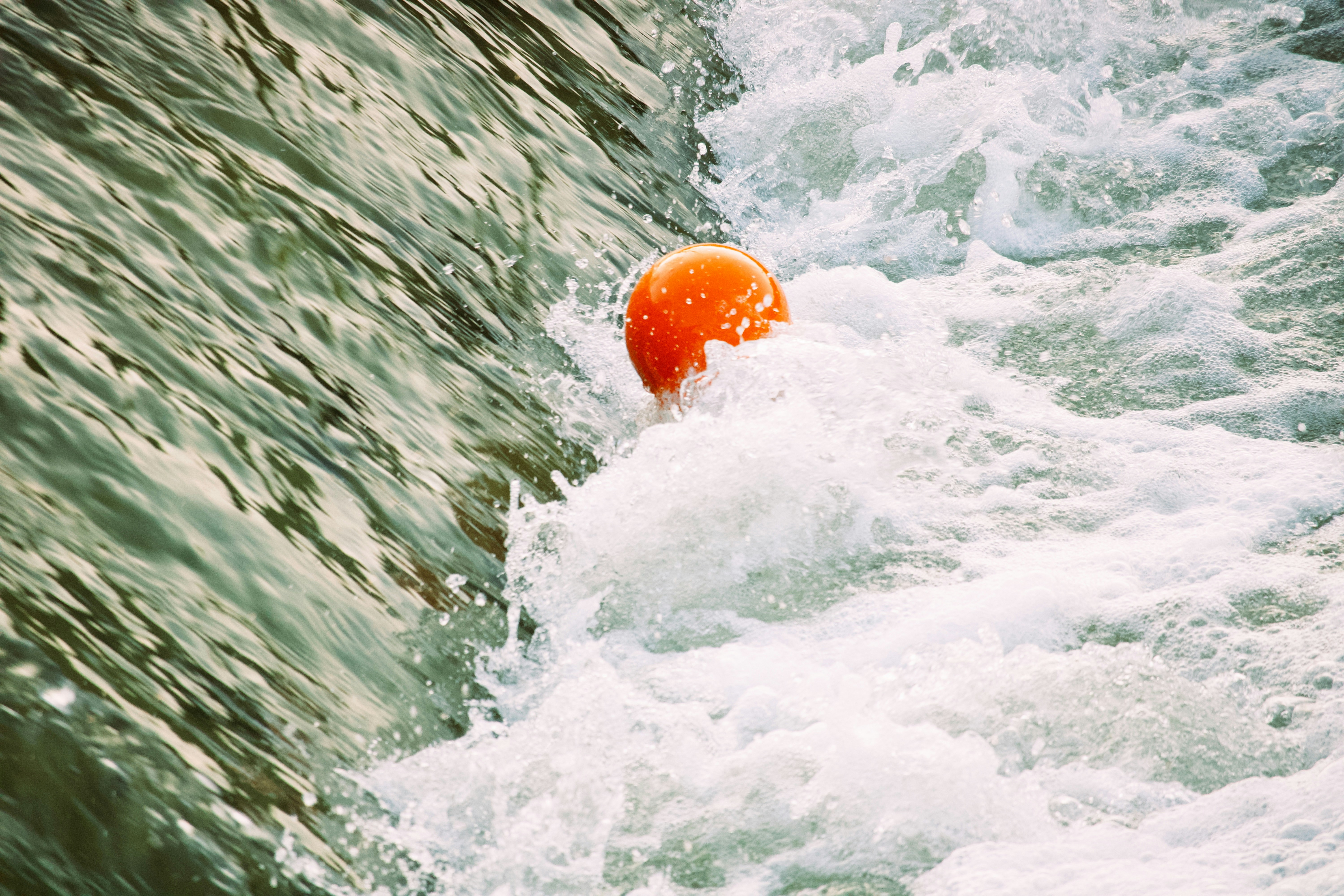 Orange Buoy Adrift in Surging Whitewater