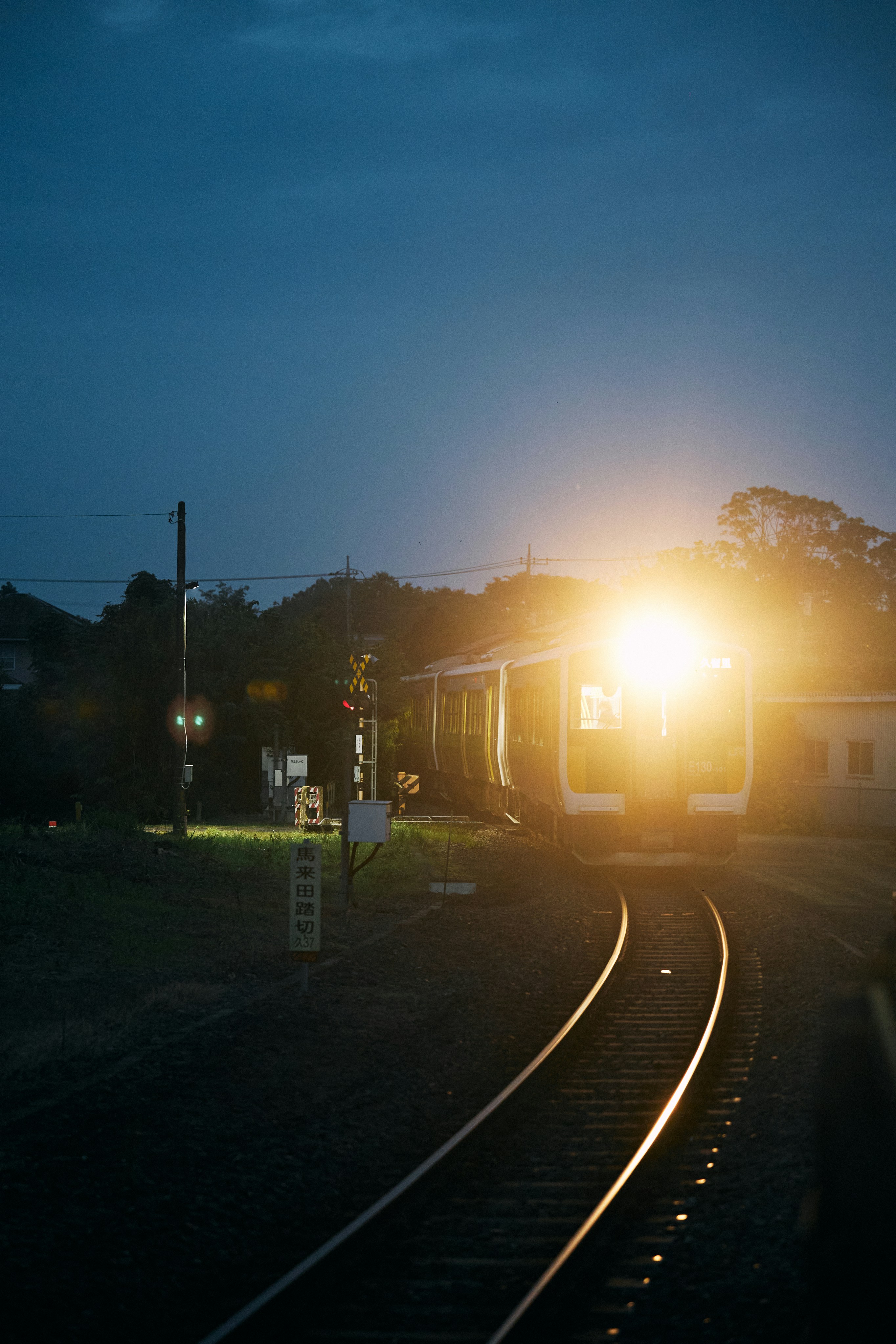 Glowing Train at Dusk: A Single Headlamp on the Curve