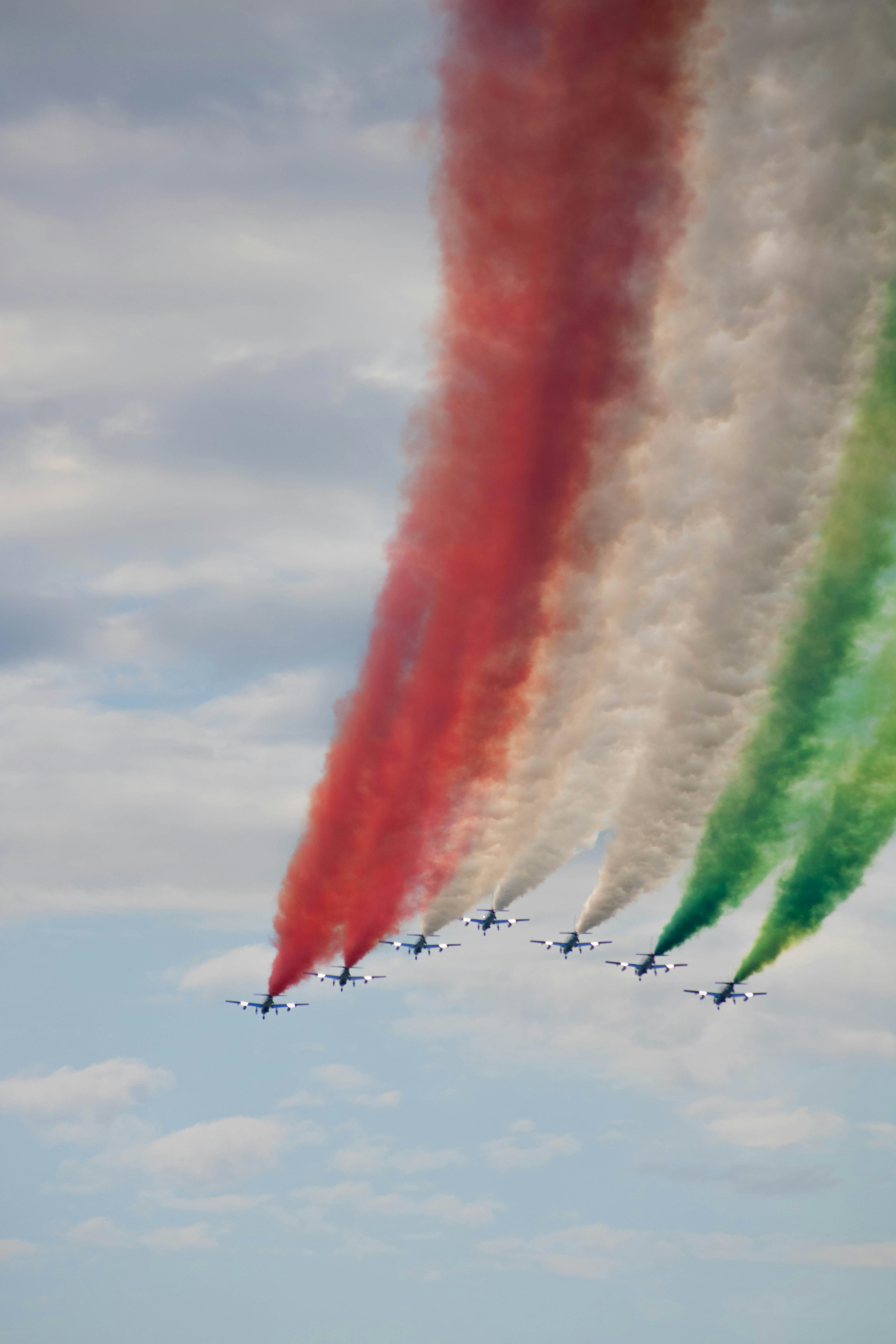 Colored smoke trail aerobatics: a line of aircraft carving the sky