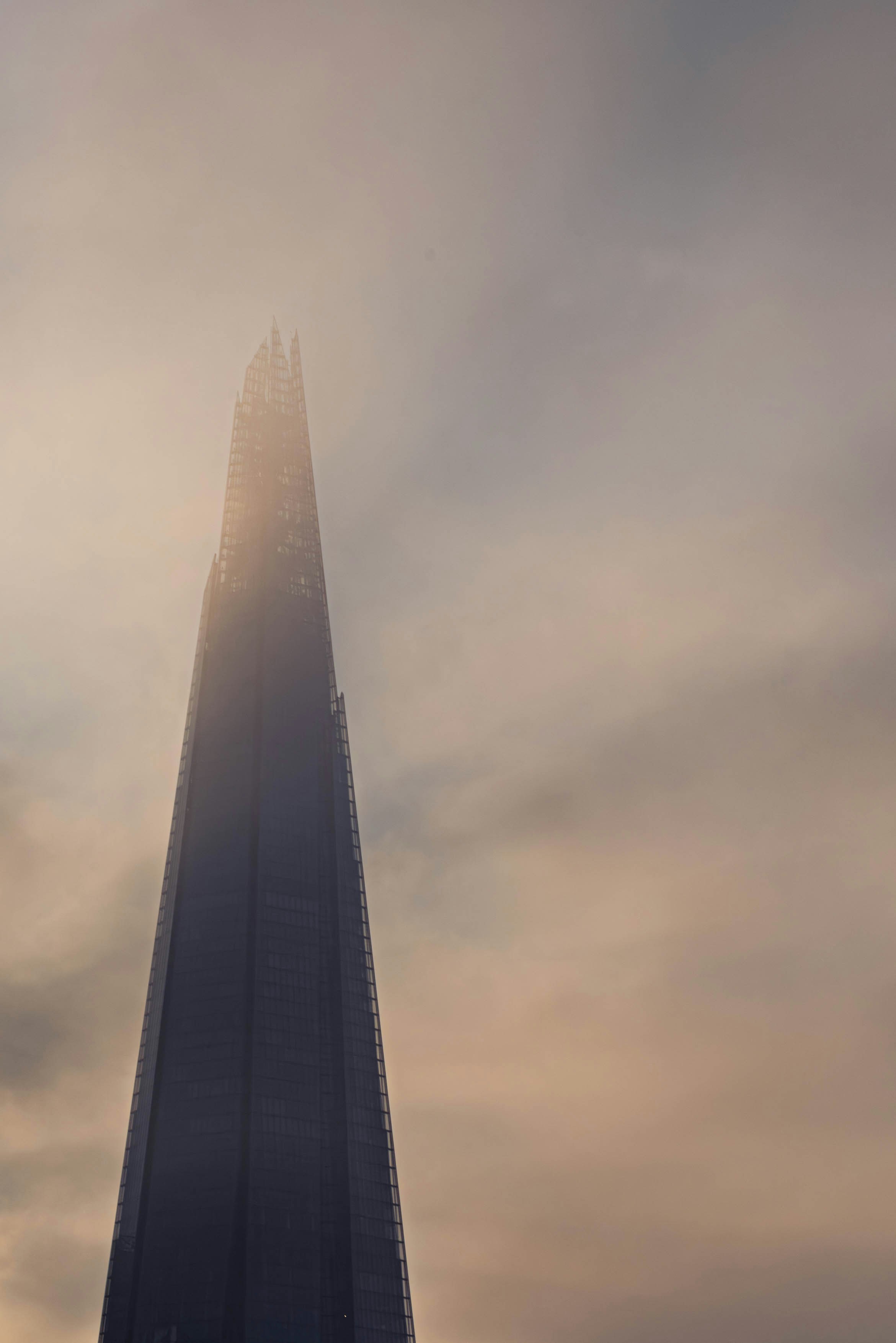 Rising Needle: The Shrouded Spire Piercing Through Evening Mist