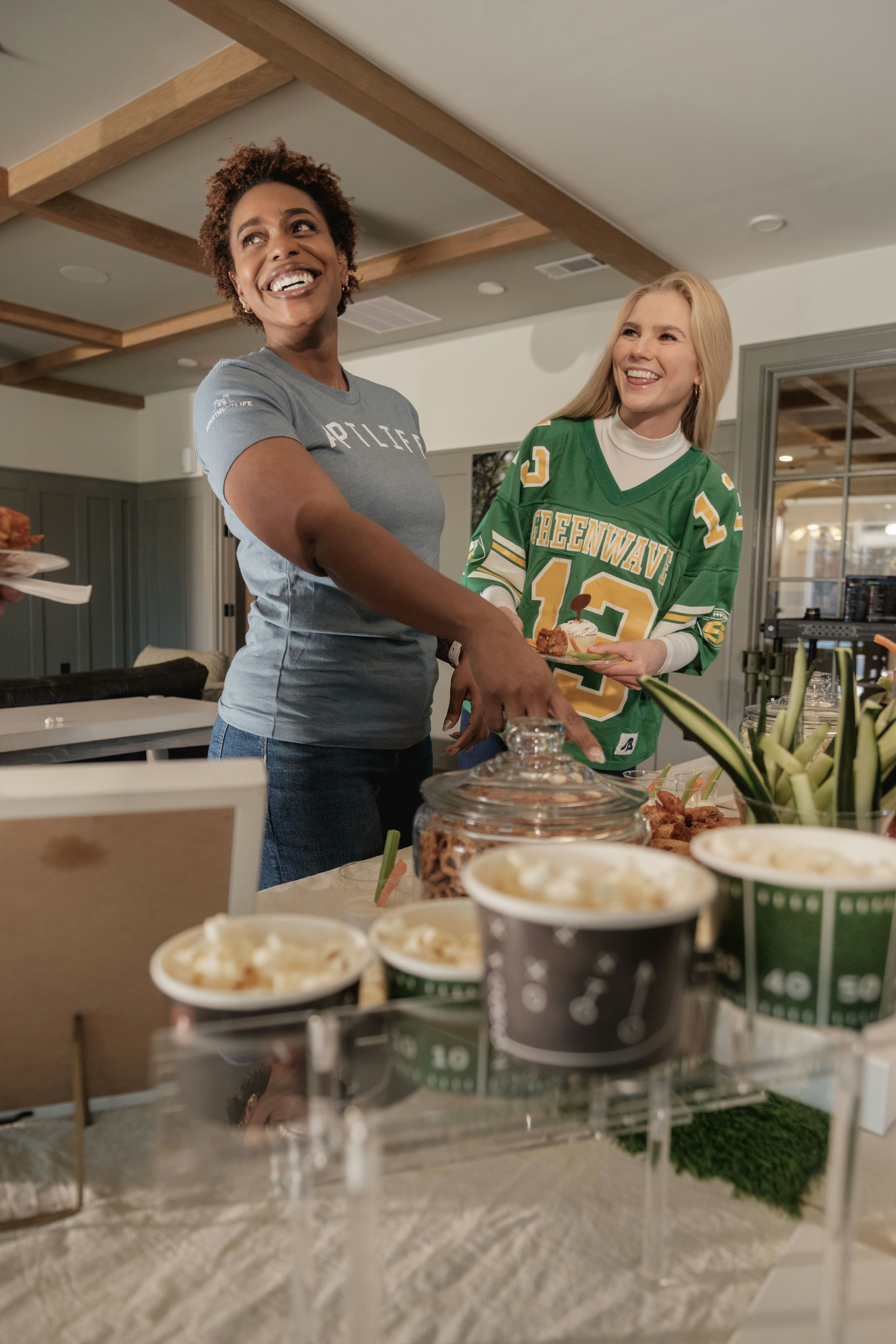 Joyful gathering around a dessert table: two friends share a smile