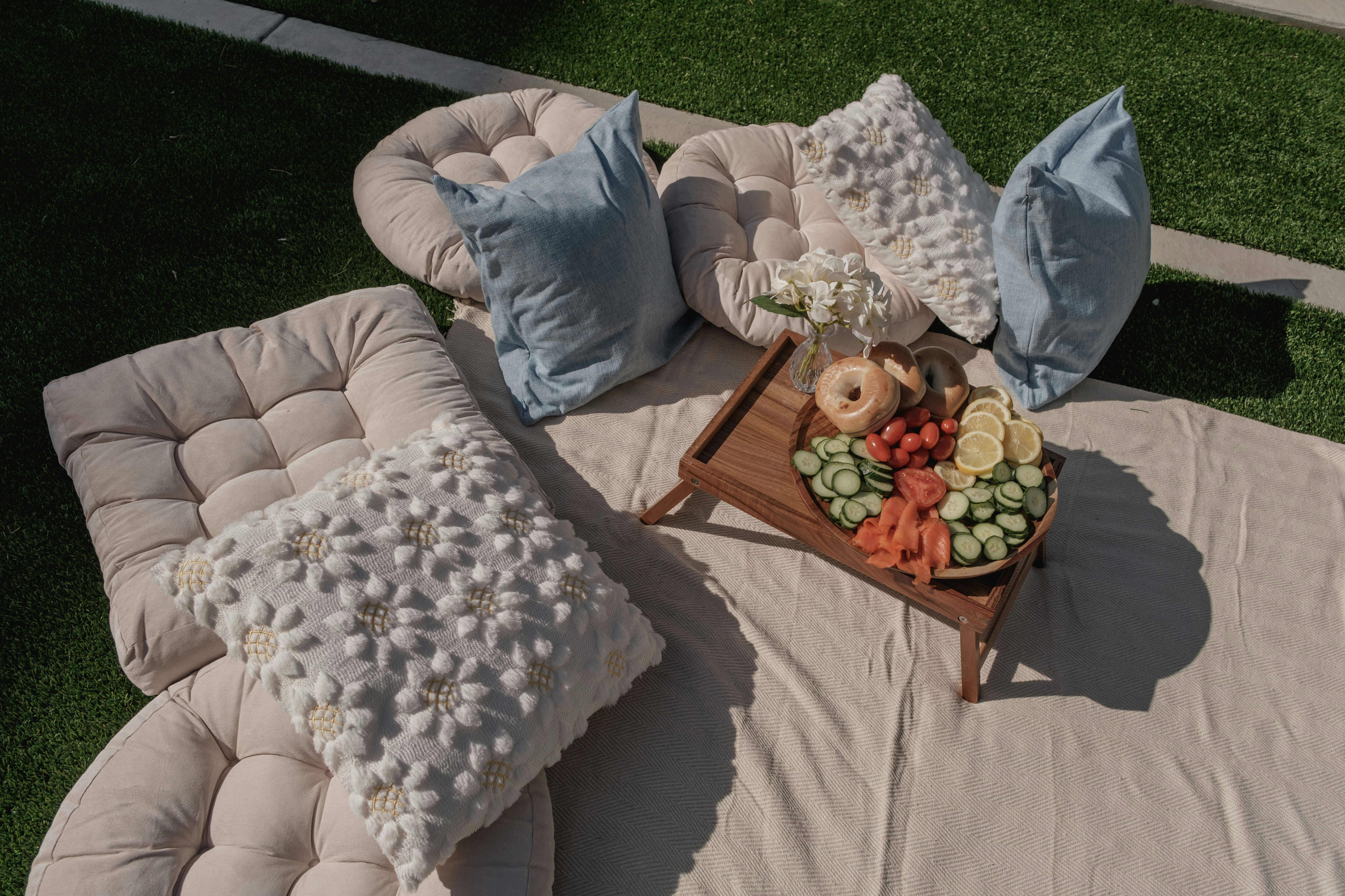 Lounge Setup Under Sun: A Picnic Tray of Fresh Fruit on a Plush Outdoor Cushion