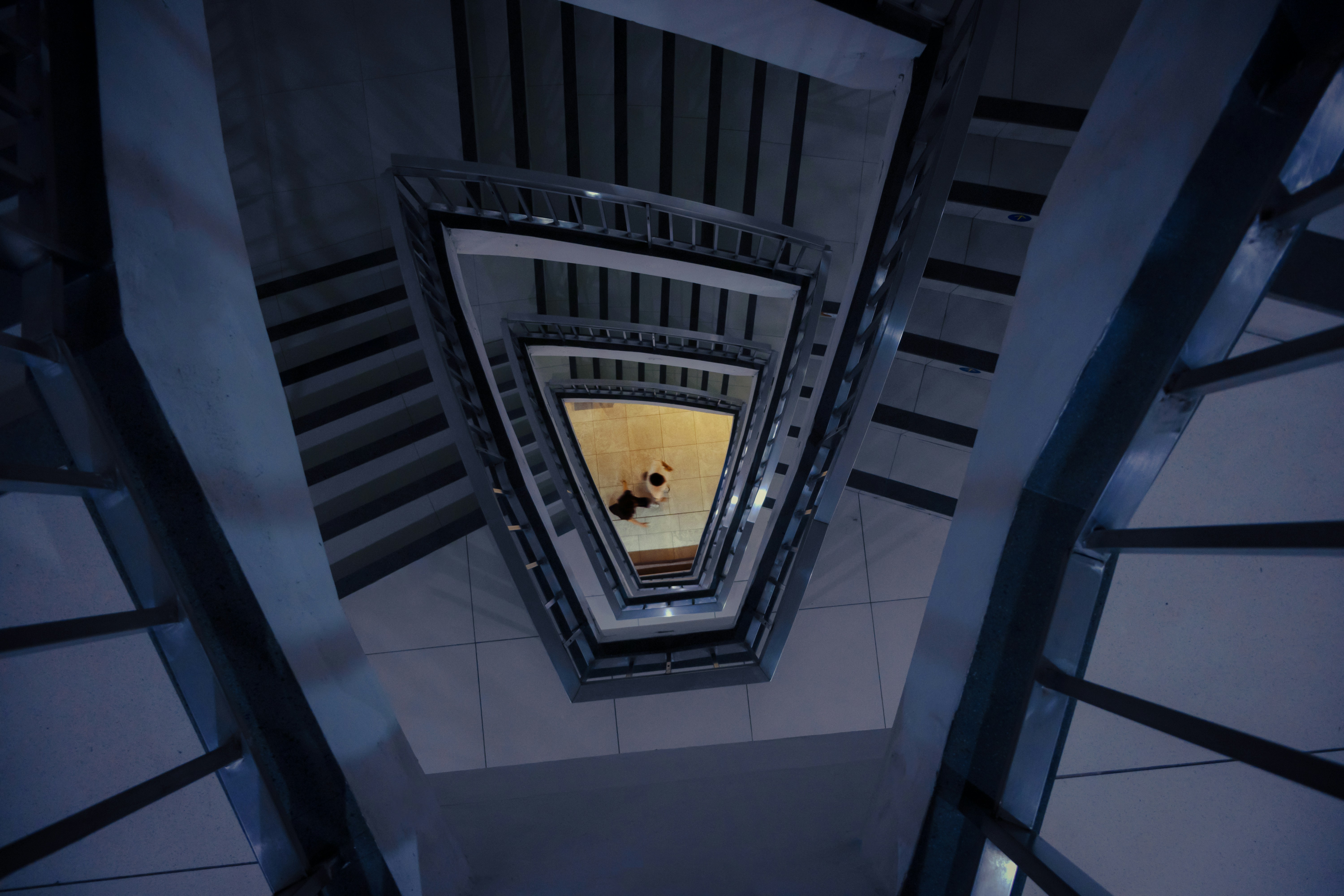 Downward Spiral: A Geometric Staircase Framing to a Glowing Aperture