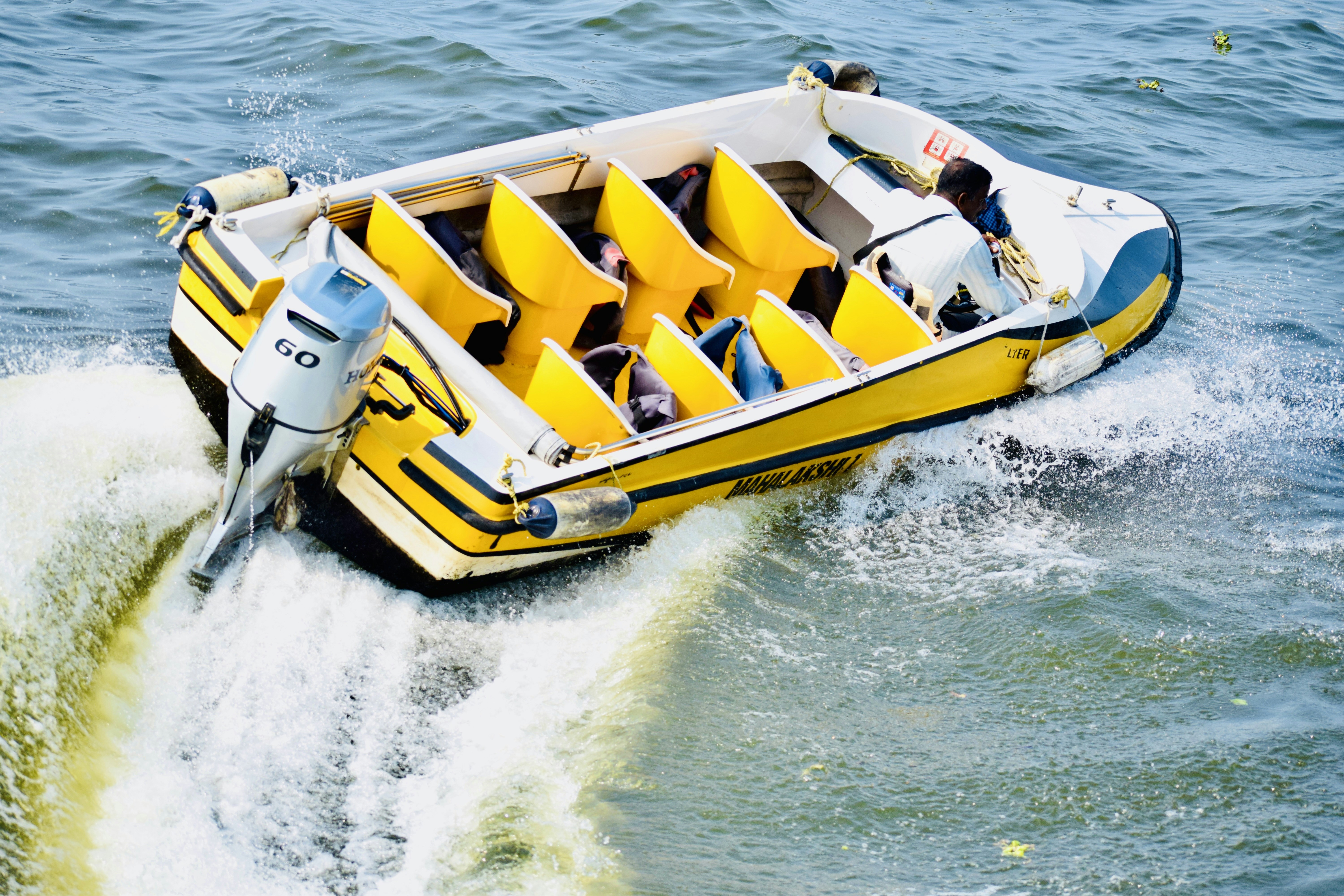 Yellow ribbed speedboat slicing through blue wake