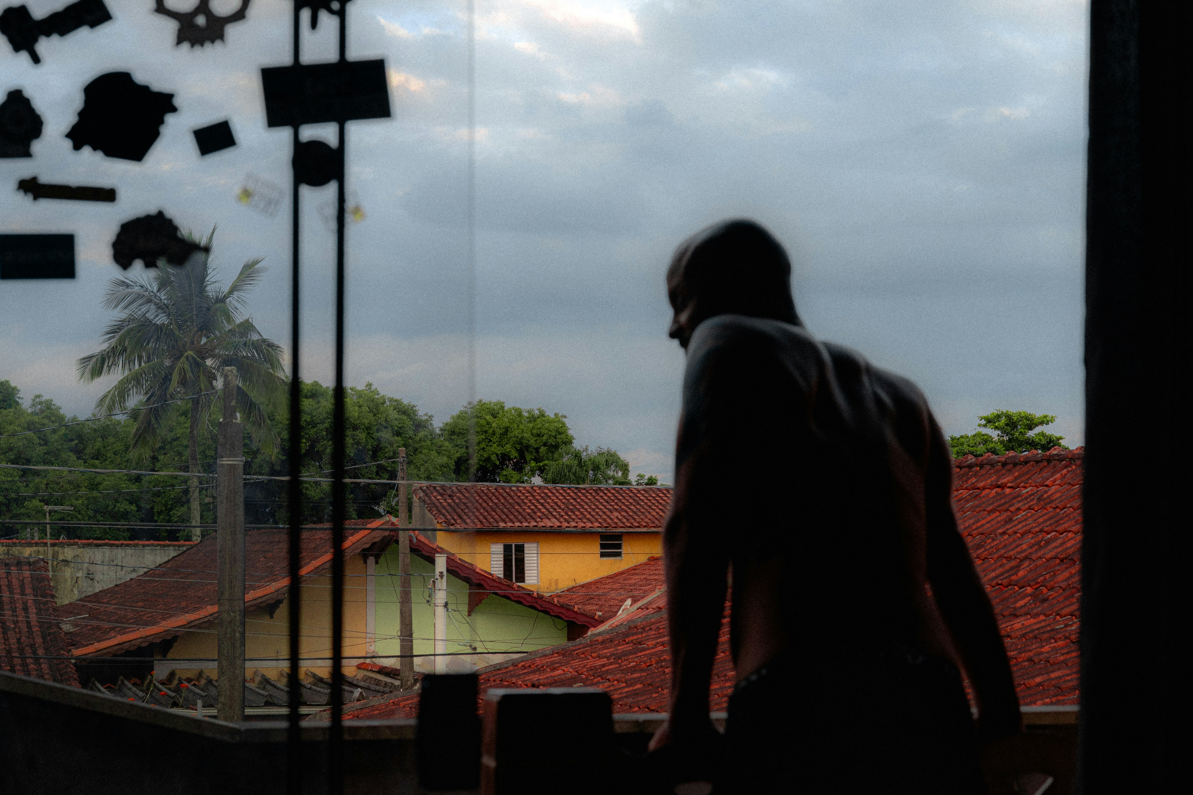 Shadowy Silhouette at Dusk: A Figure Framed by Rooftops