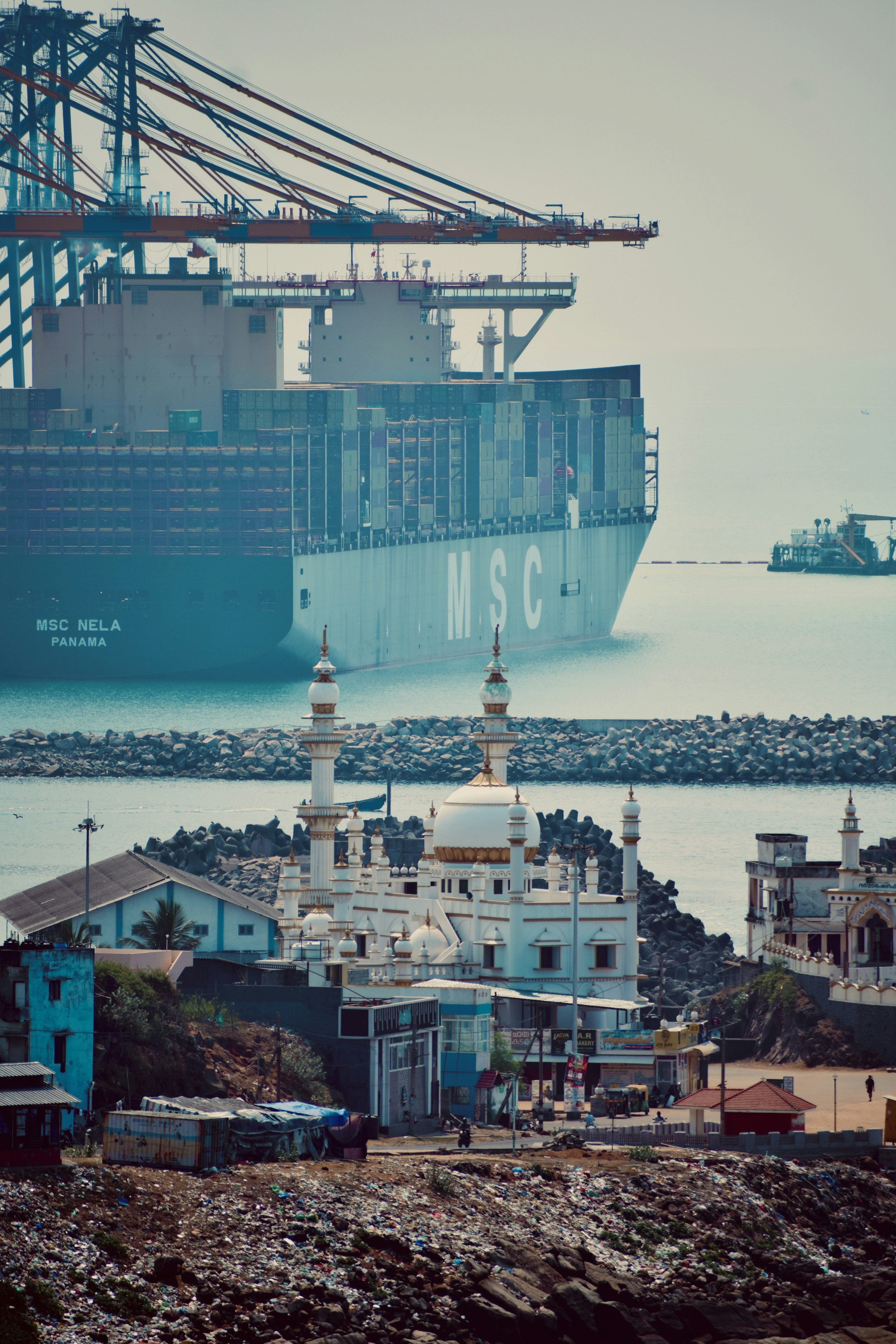 Harbor Ferry at Dusk: A Cargo Giant Overlooking a Mosque Town