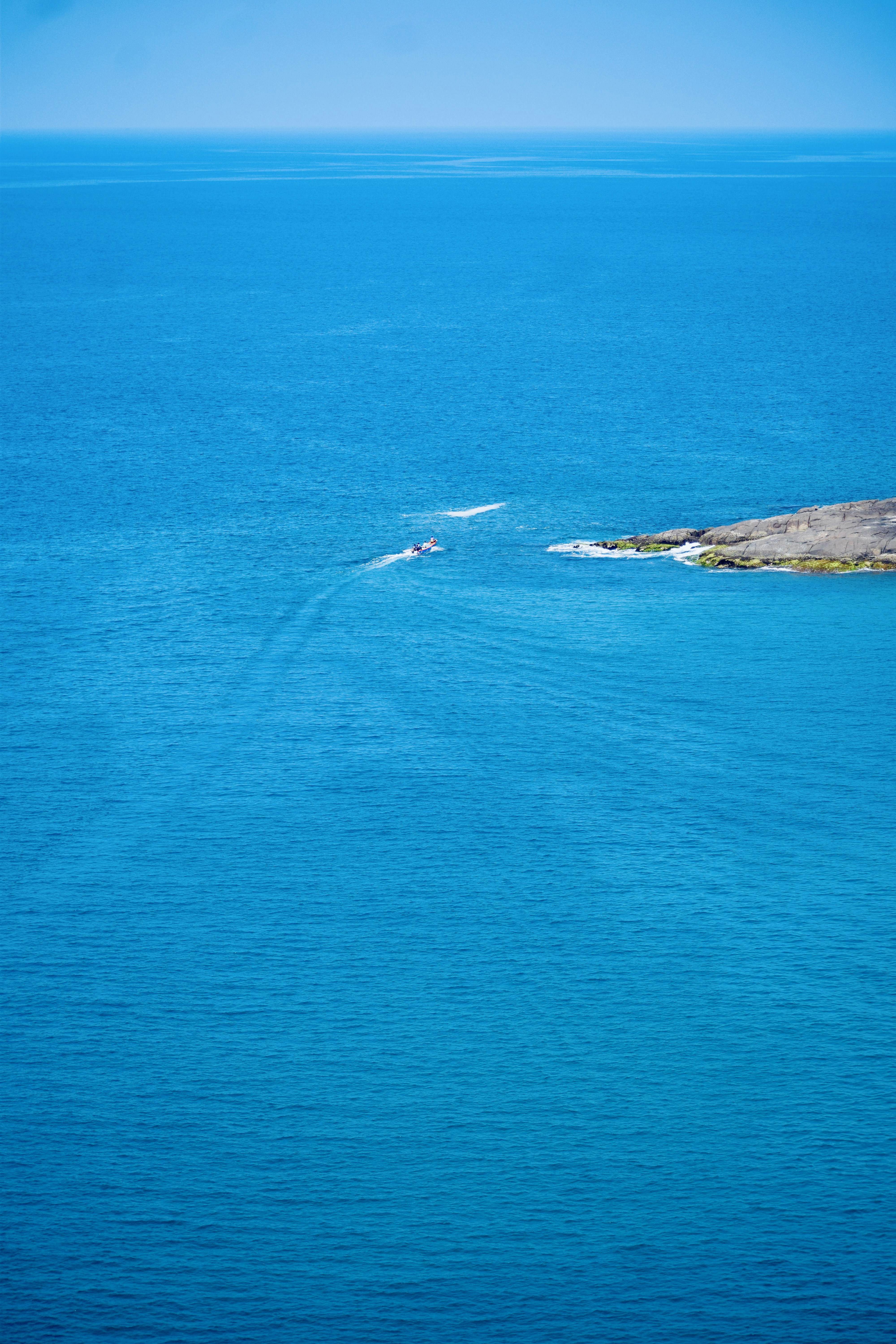 Vessel wake skimming a blue horizon