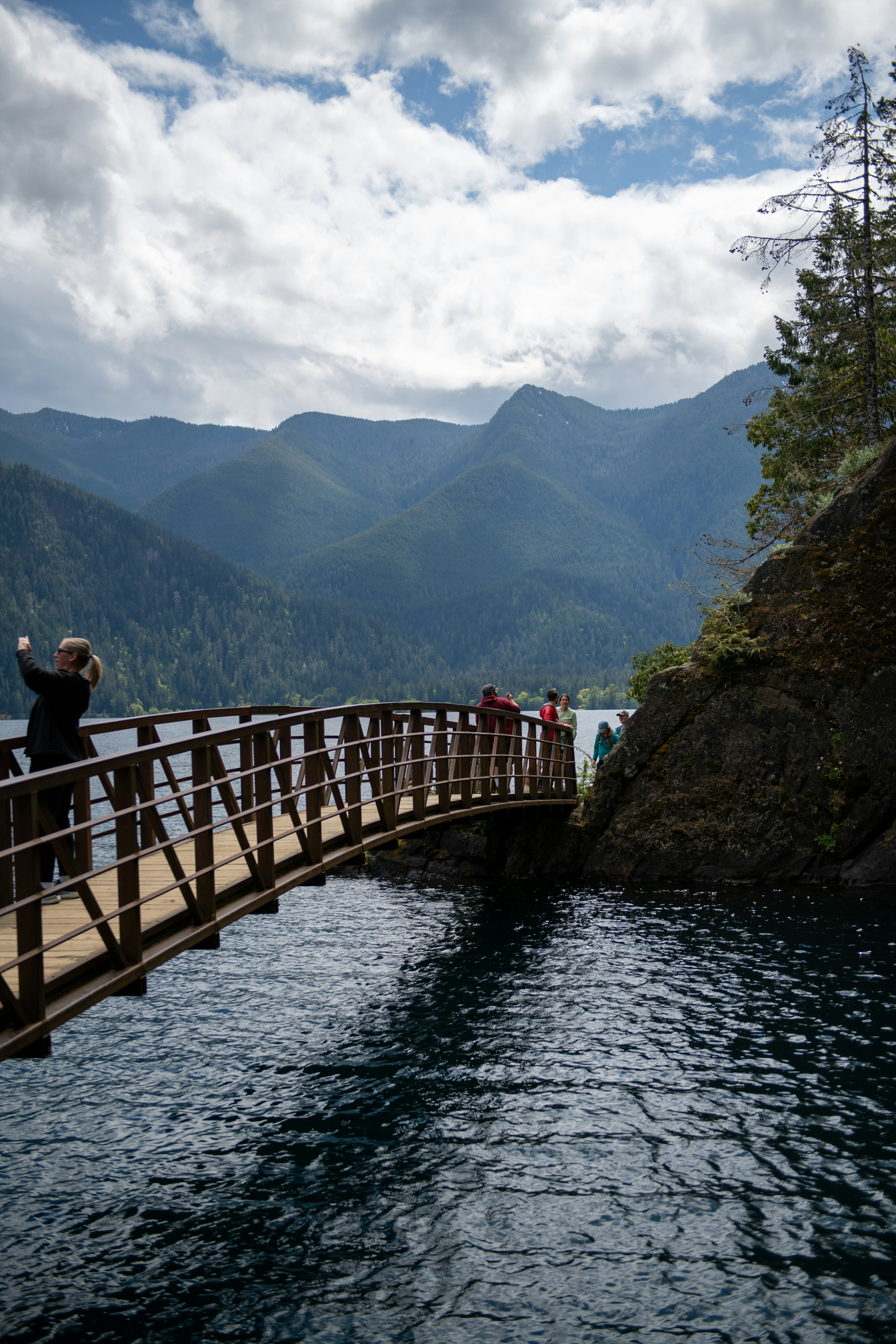 Bridge of Views: Tourists on a Cliffside Walk Over a Mountain Lake