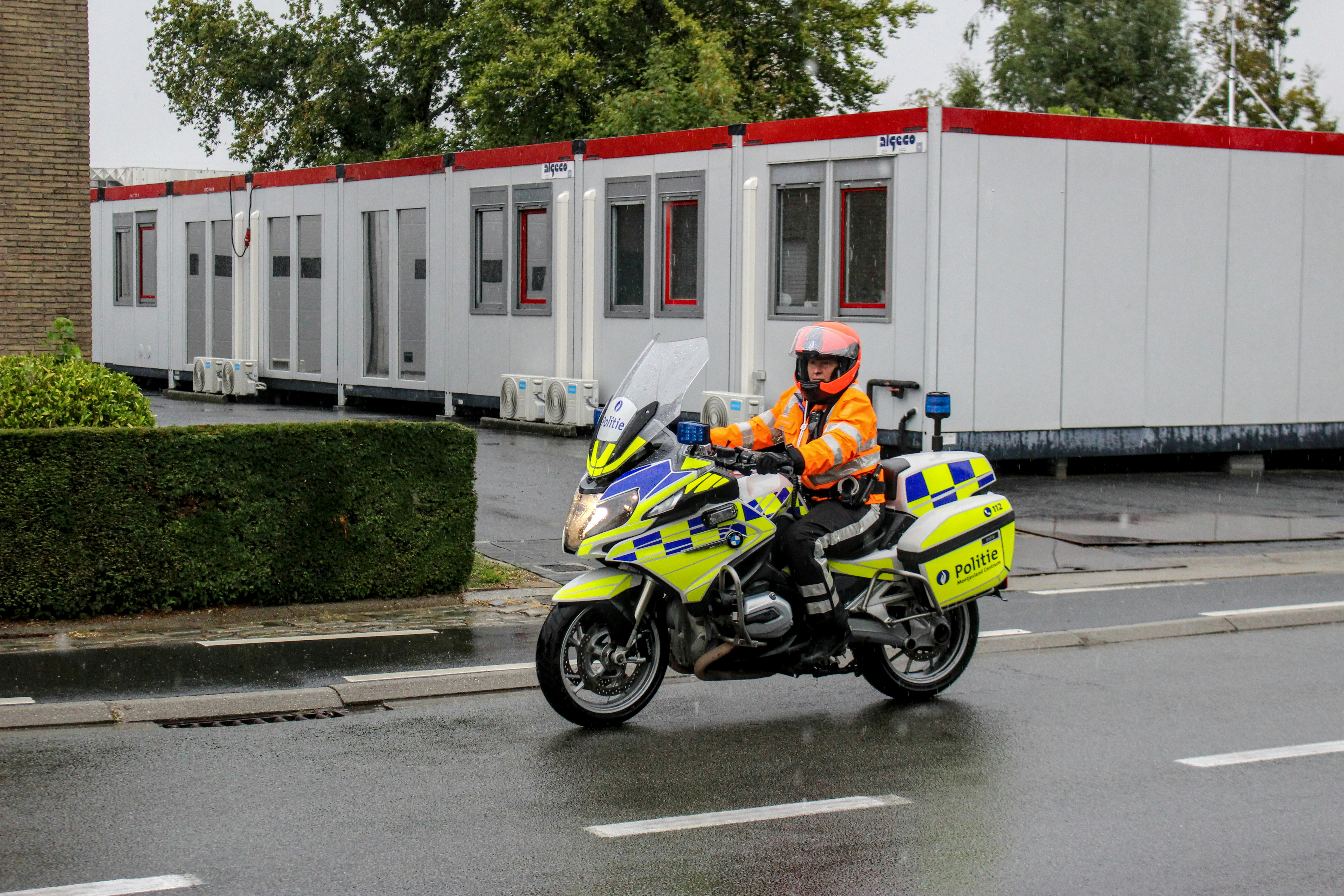 Policeman on a bright neon motorcycle patrolling a quiet urban street