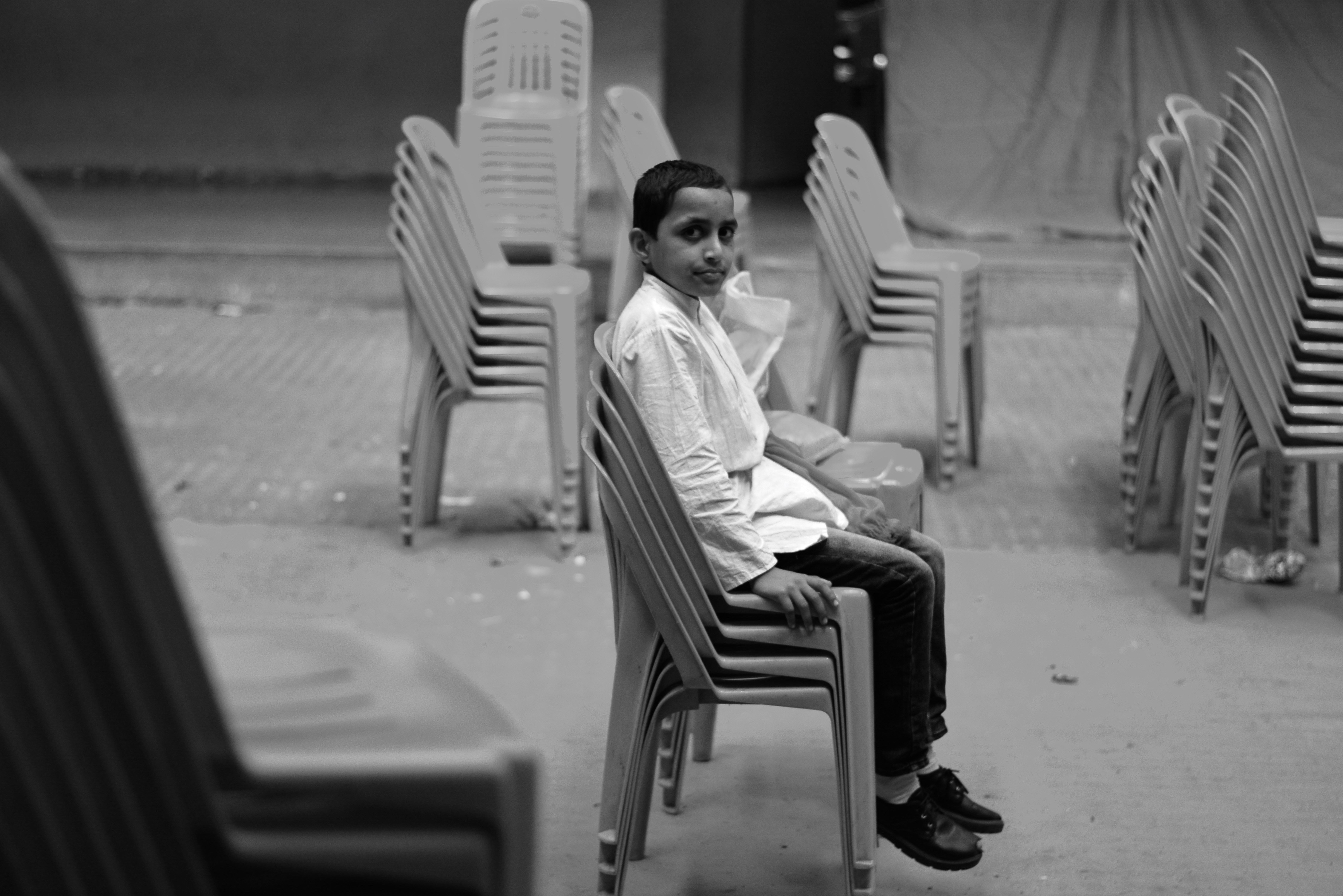 Quiet Portrait in a Sea of Stacked Chairs