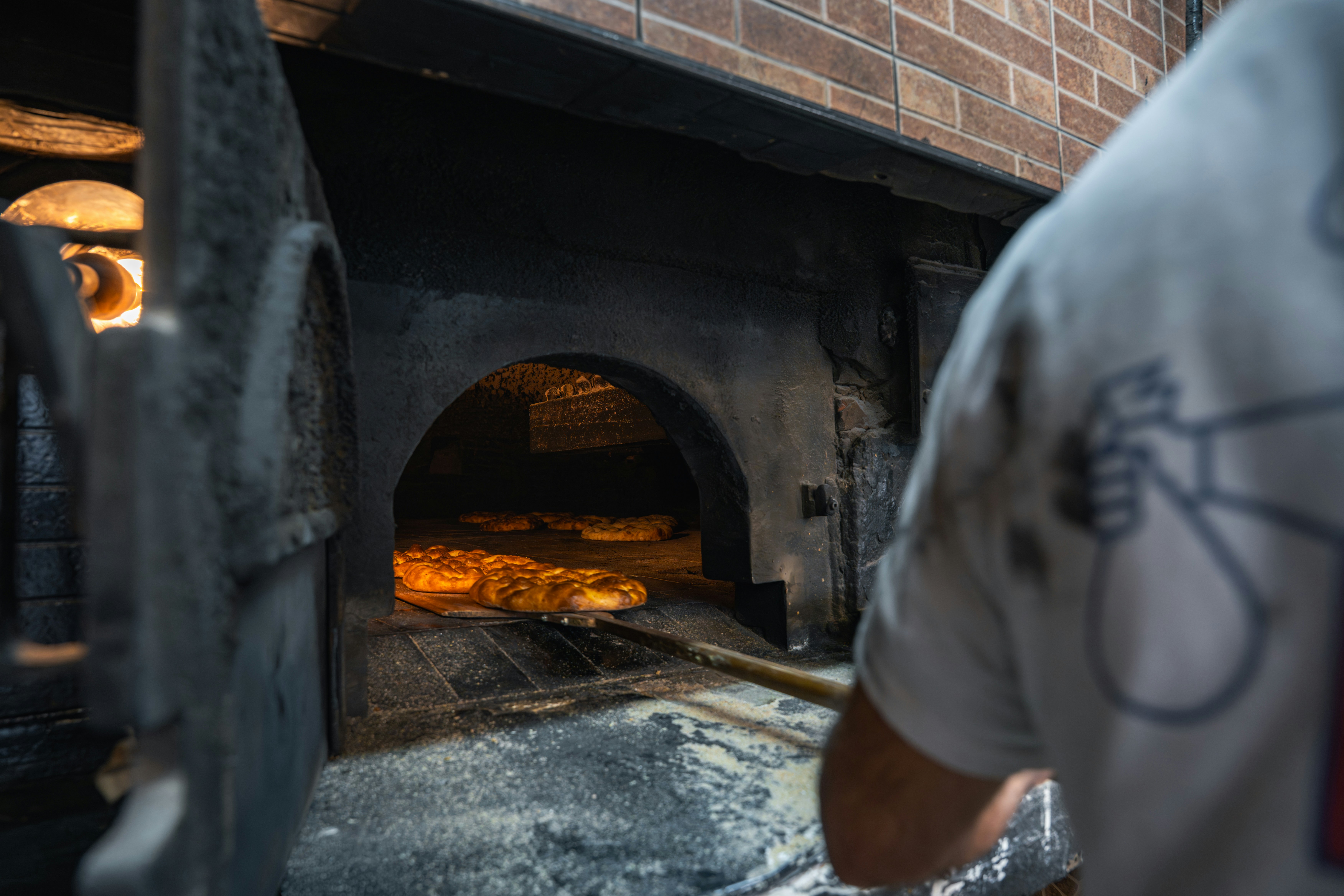 Heat of the Bake: Bread Emerging from the Brick Oven