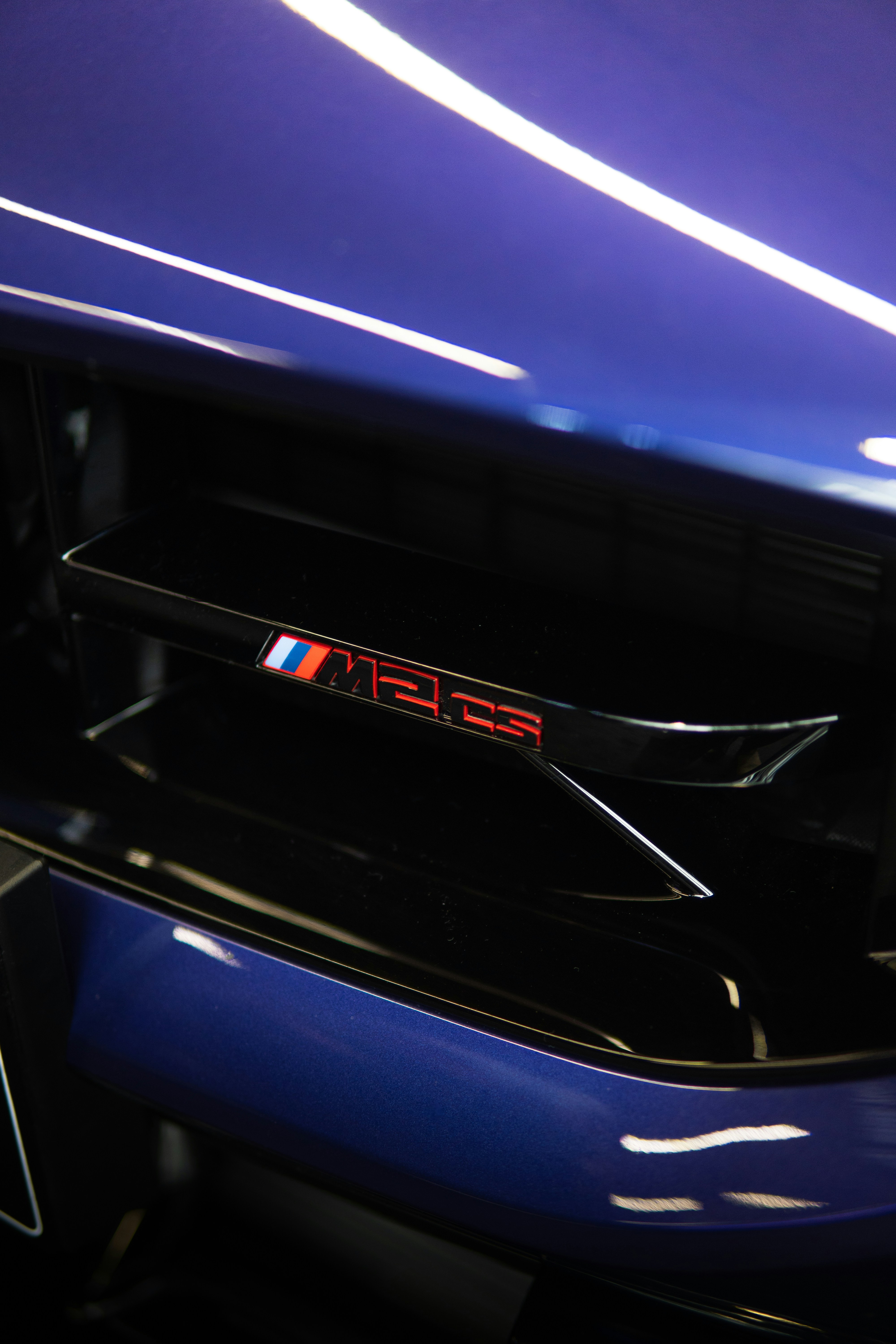 Blue metallic lines: the M4 E45 badge glinting in a luxury cockpit