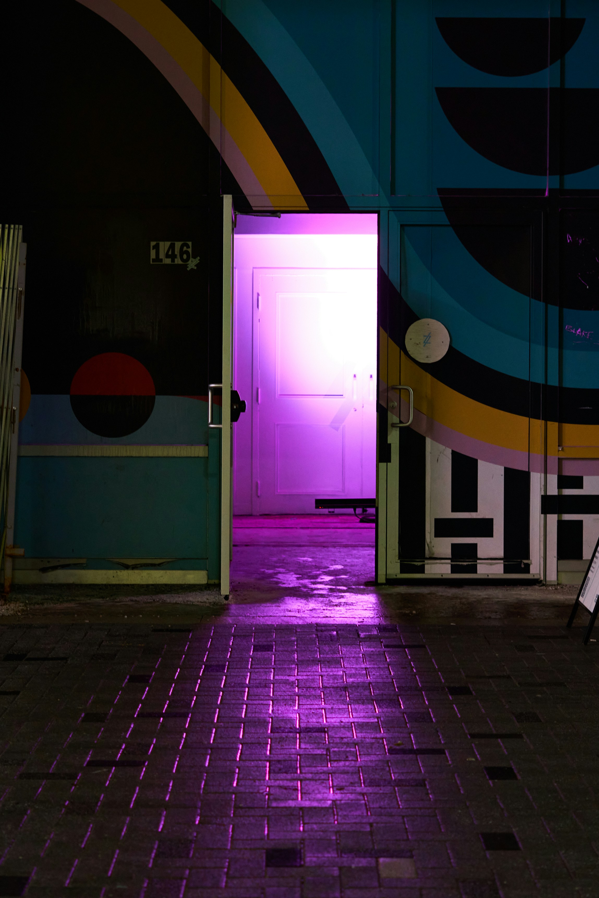 Neon Portal: A Purple Door Emerges from the Graffiti Night