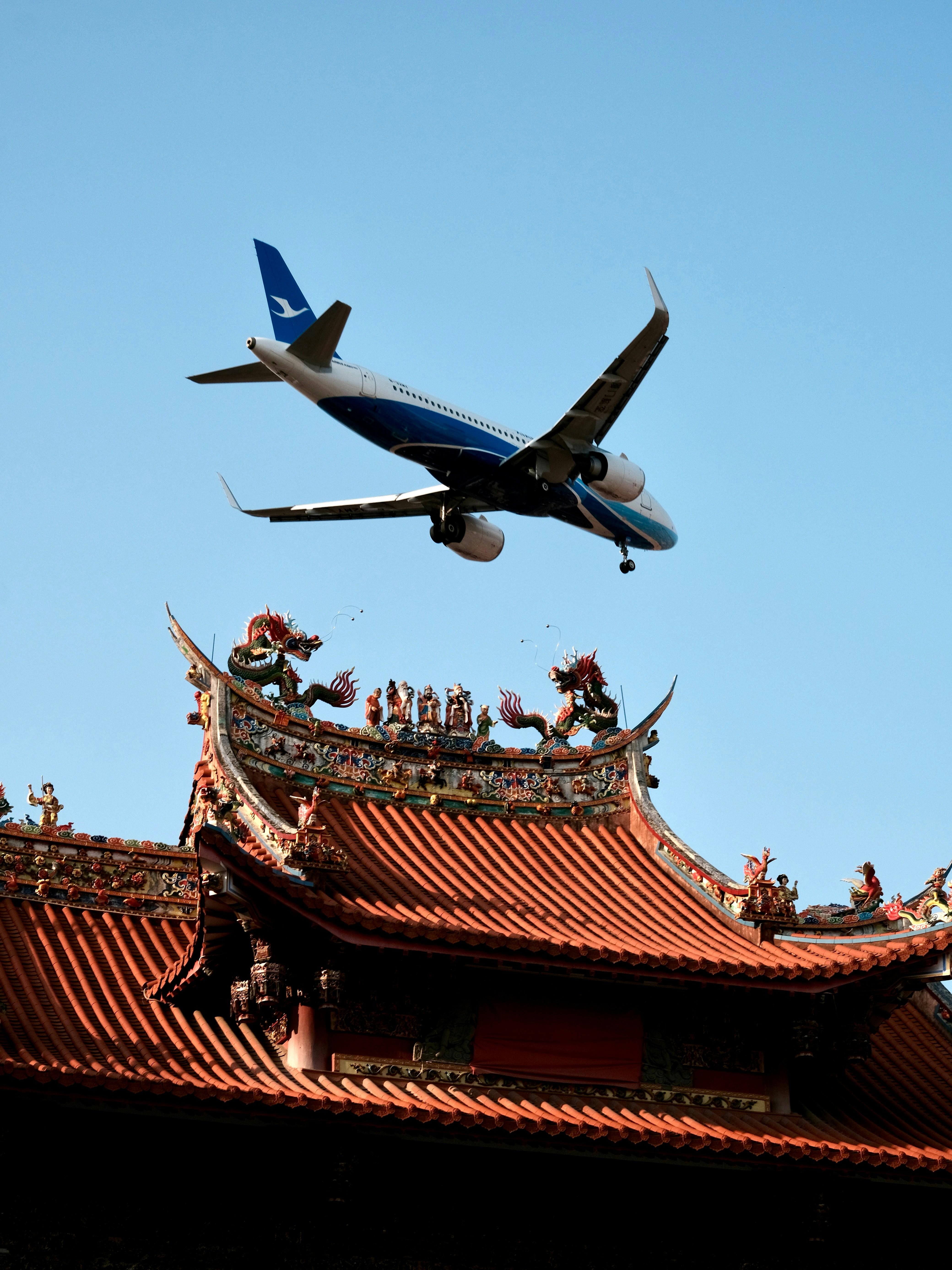 Jet Above the Temple: A Modern Aircraft Draped over Traditional Rooflines