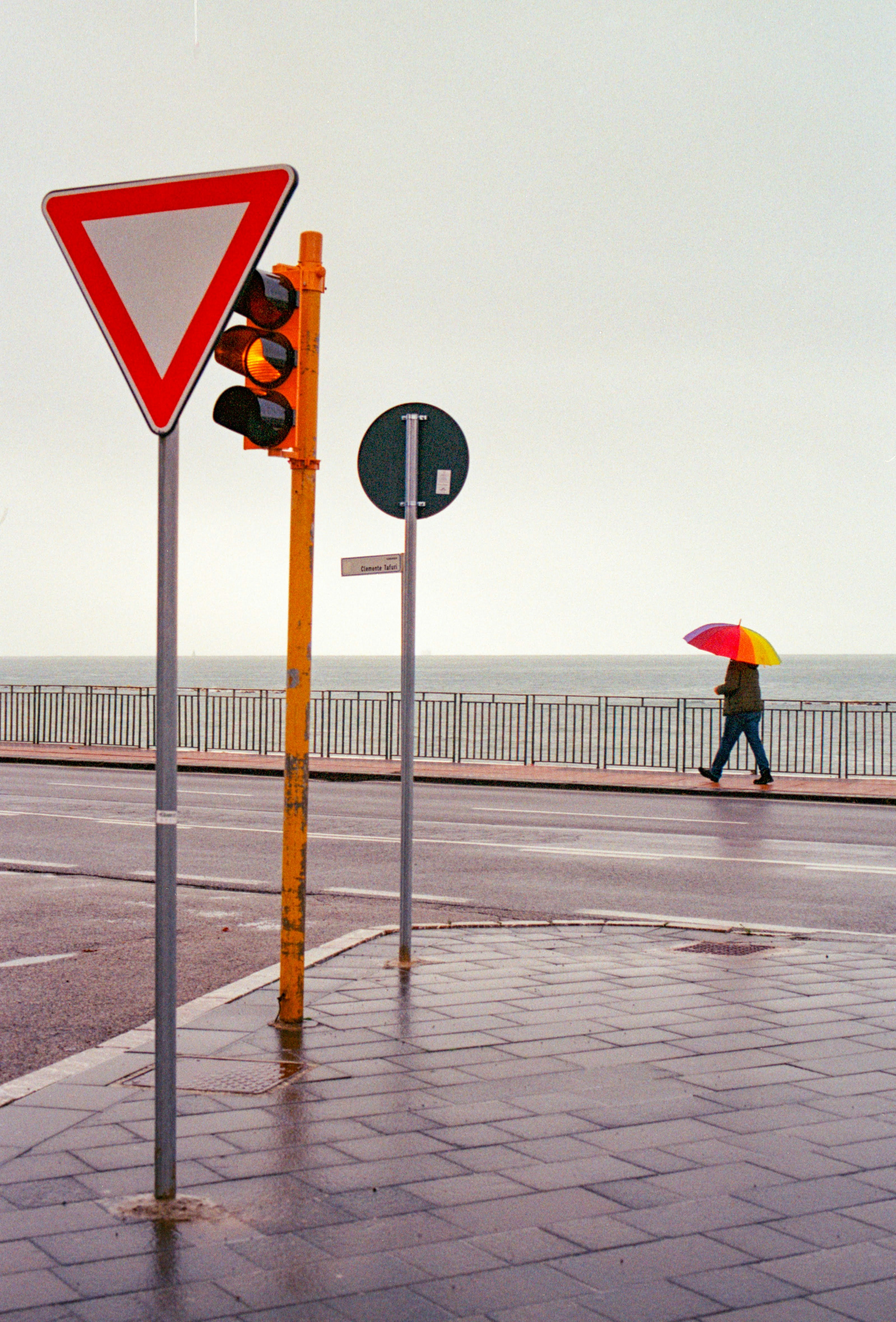 It was a rainy day and I was wandering through the city without much motivation when I noticed a man with a colorful umbrella. Three poles caught my eye — together they hinted at a triangle. I framed the shot and waited. When he walked into the scene, he completed the shape, and I pressed the shutter.