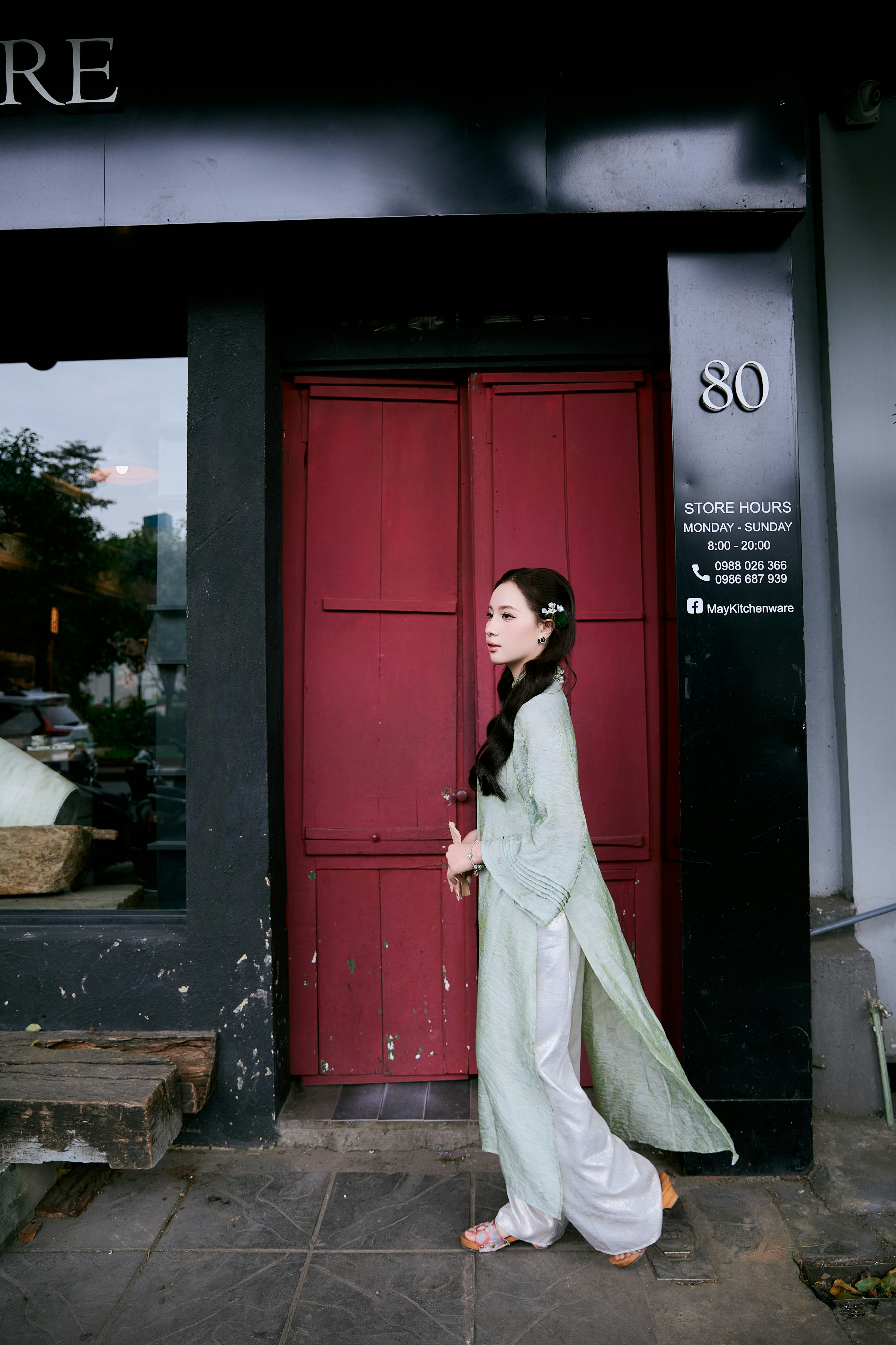 A Vietnamese girl in a turquoise ao dai dress in a cafe.