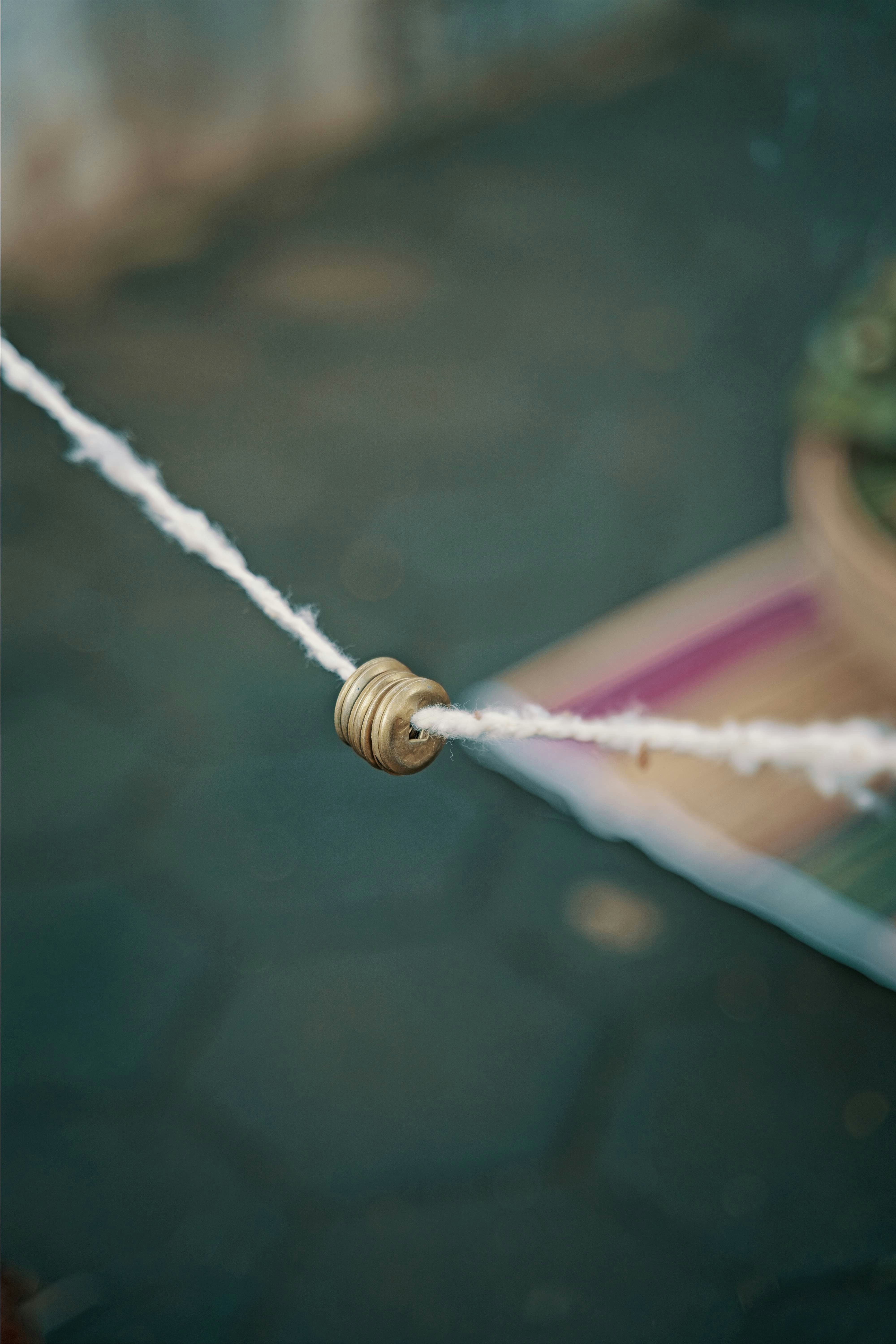 Line of Thread: A Brass Pulley Anchored in a Sea of Blur