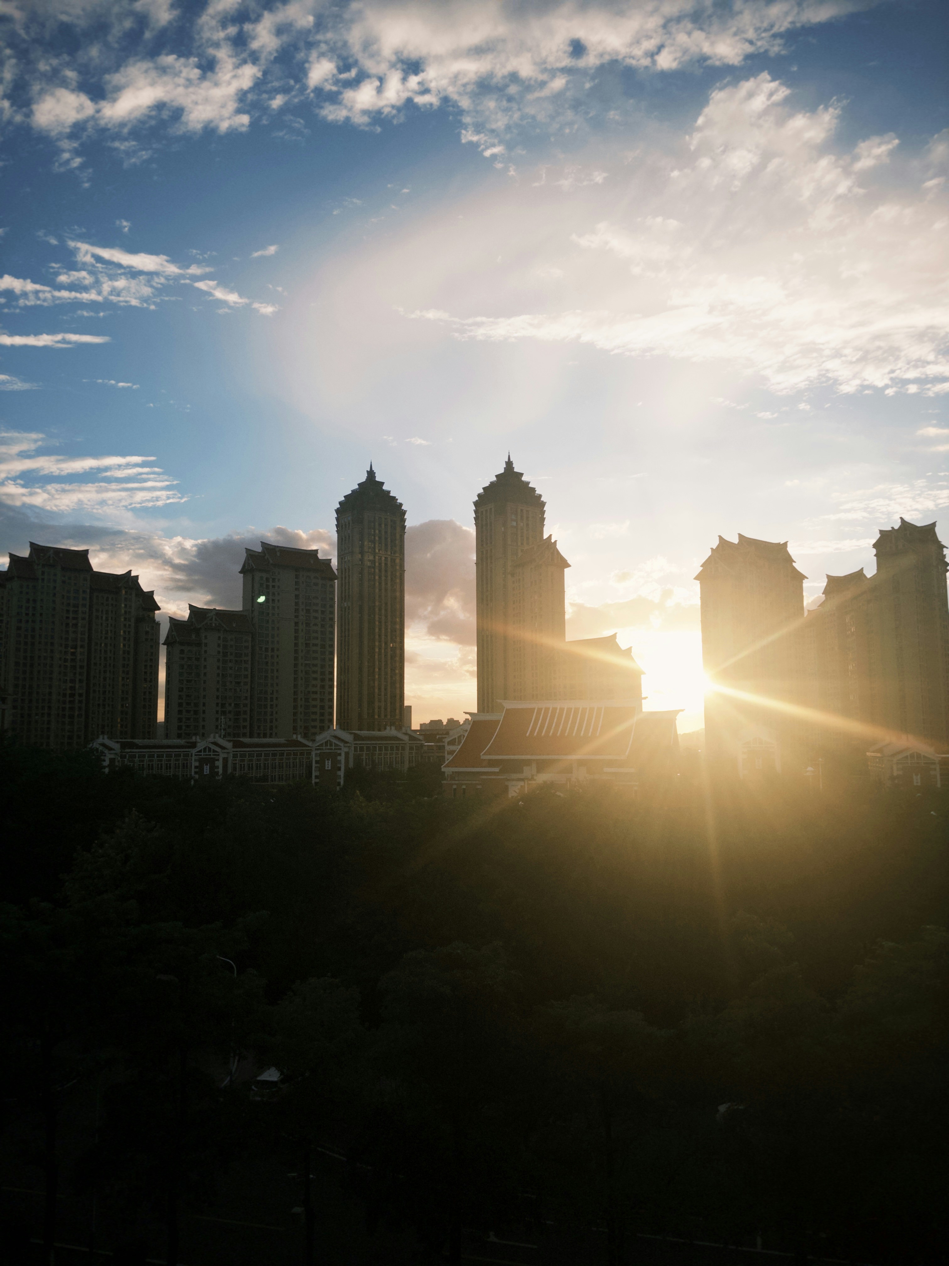 Dawn Over the Skyline: Sunburst Between Tall Towers