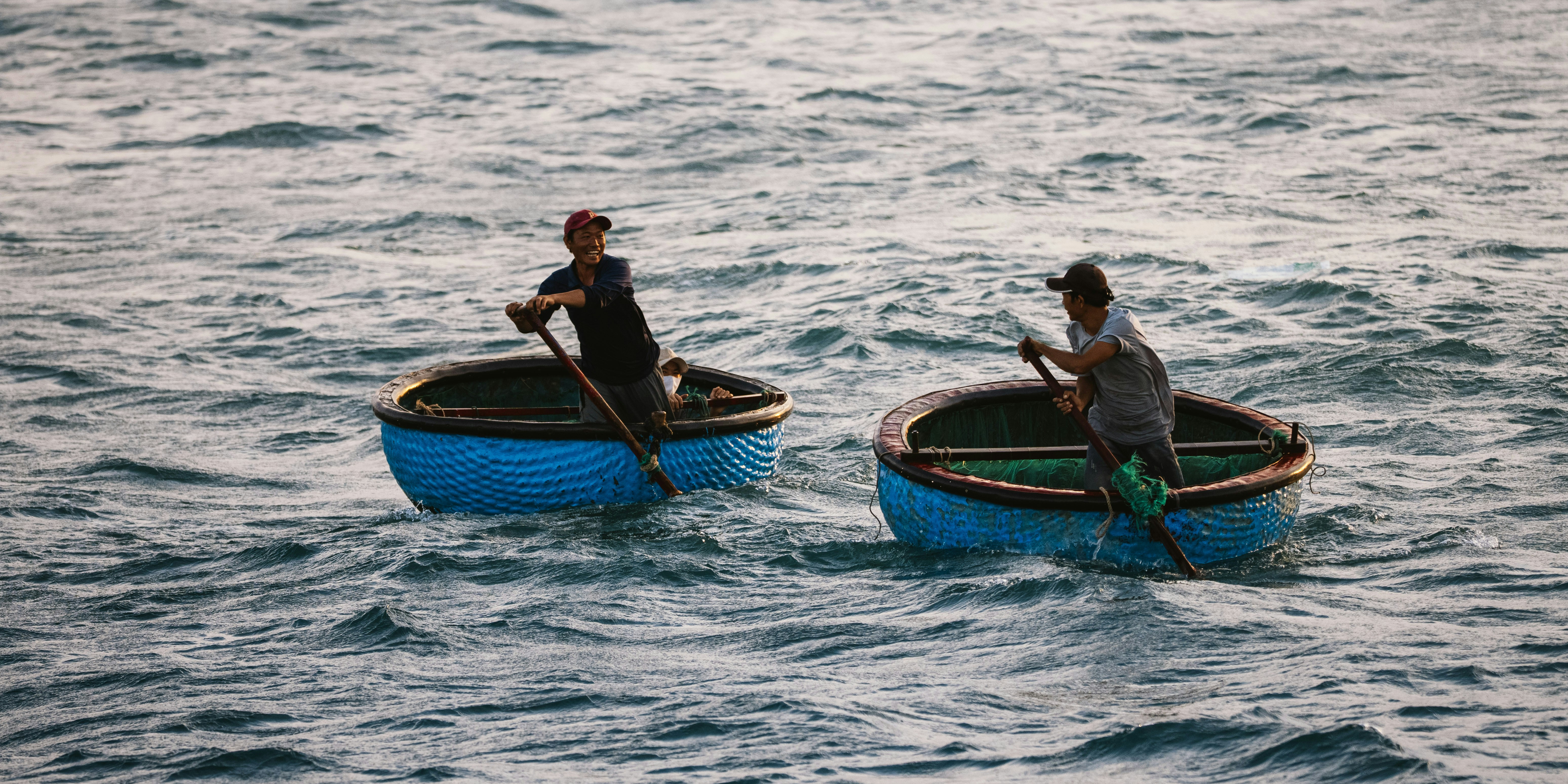 Two Blue Boats Cut Across Quiet Waves