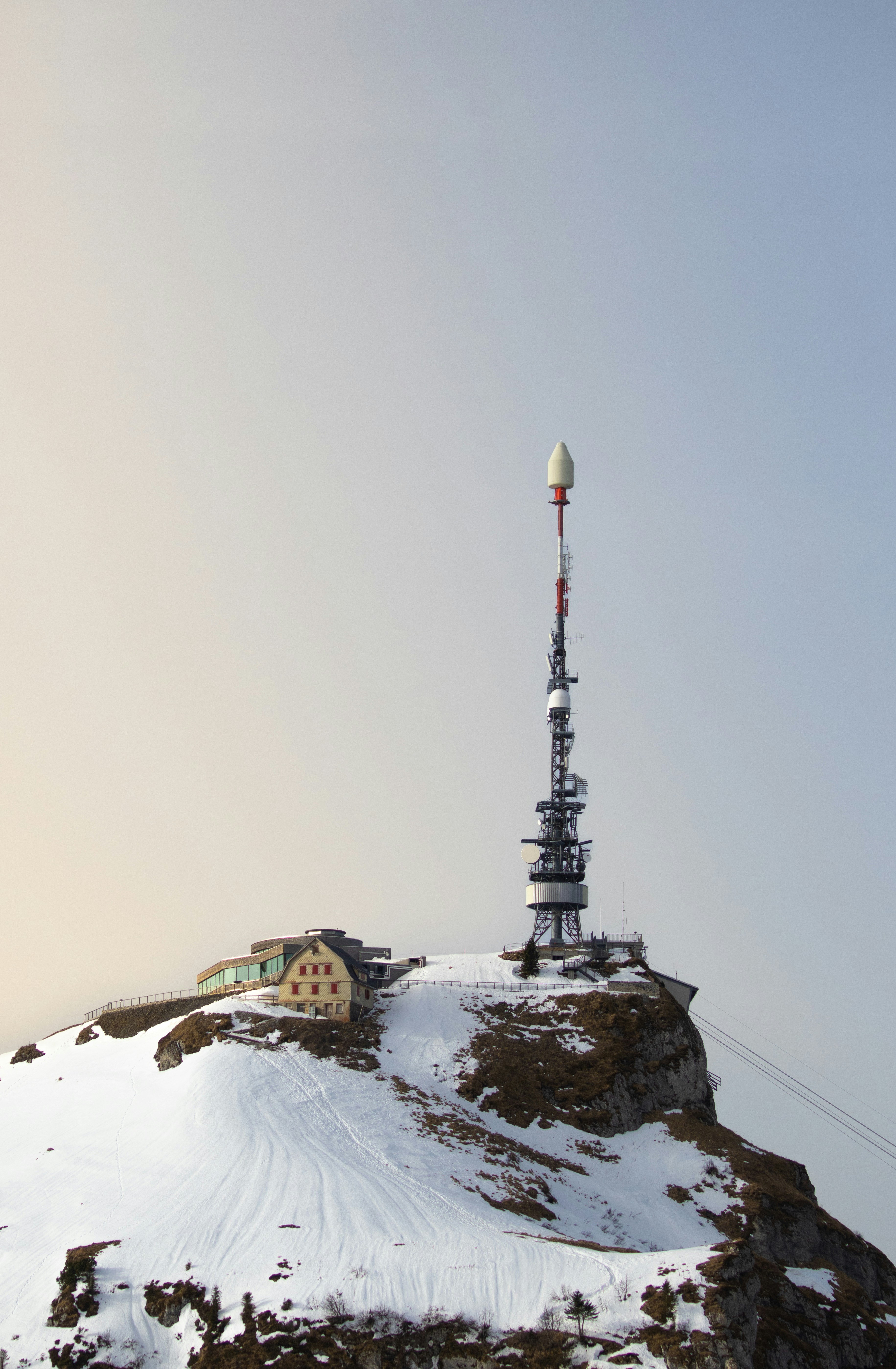 Signal Tower Reaching for the Sky from Snow-Capped Summit