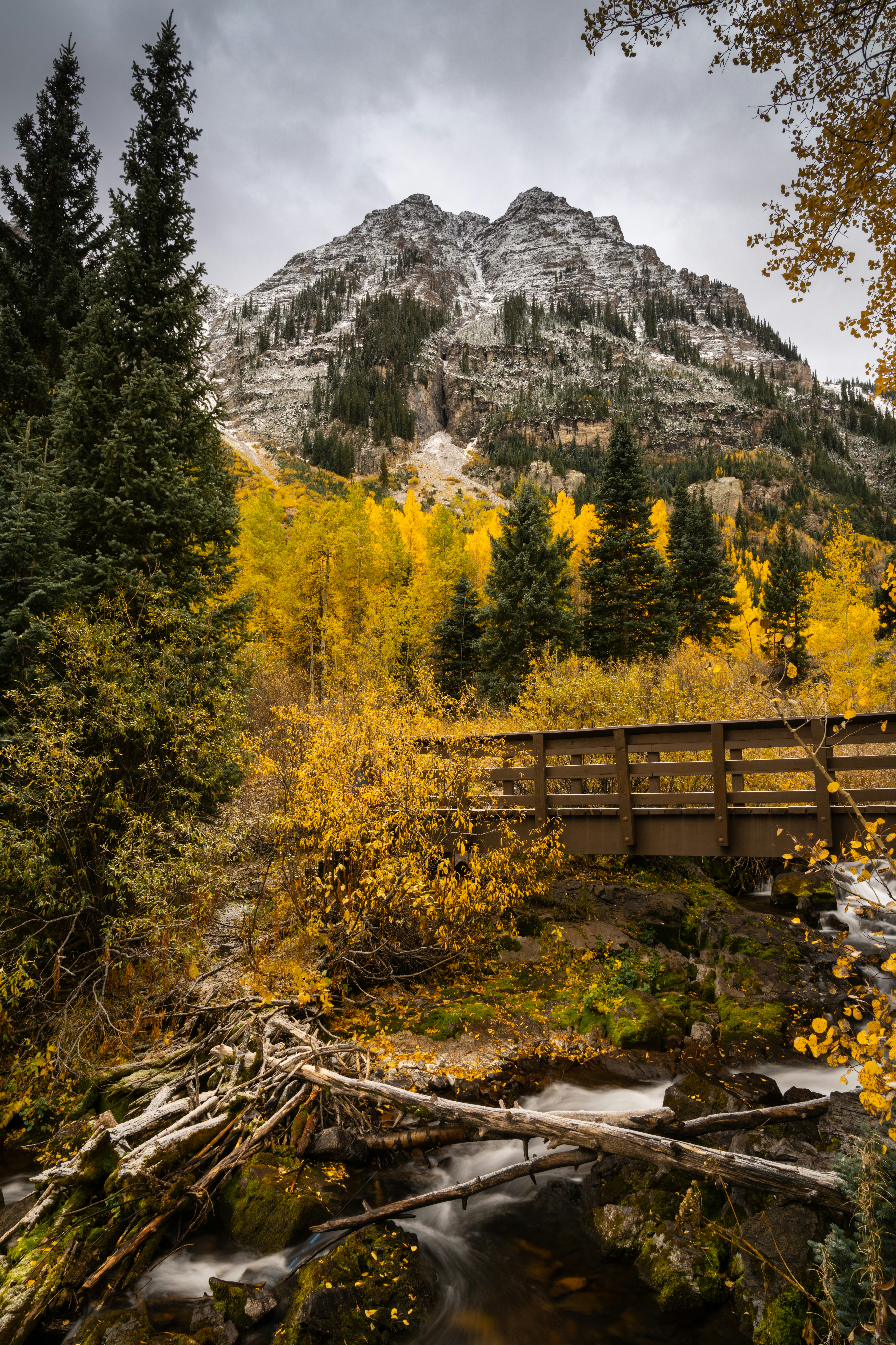 Golden aspens under a granite peak: autumn at the wooden bridge