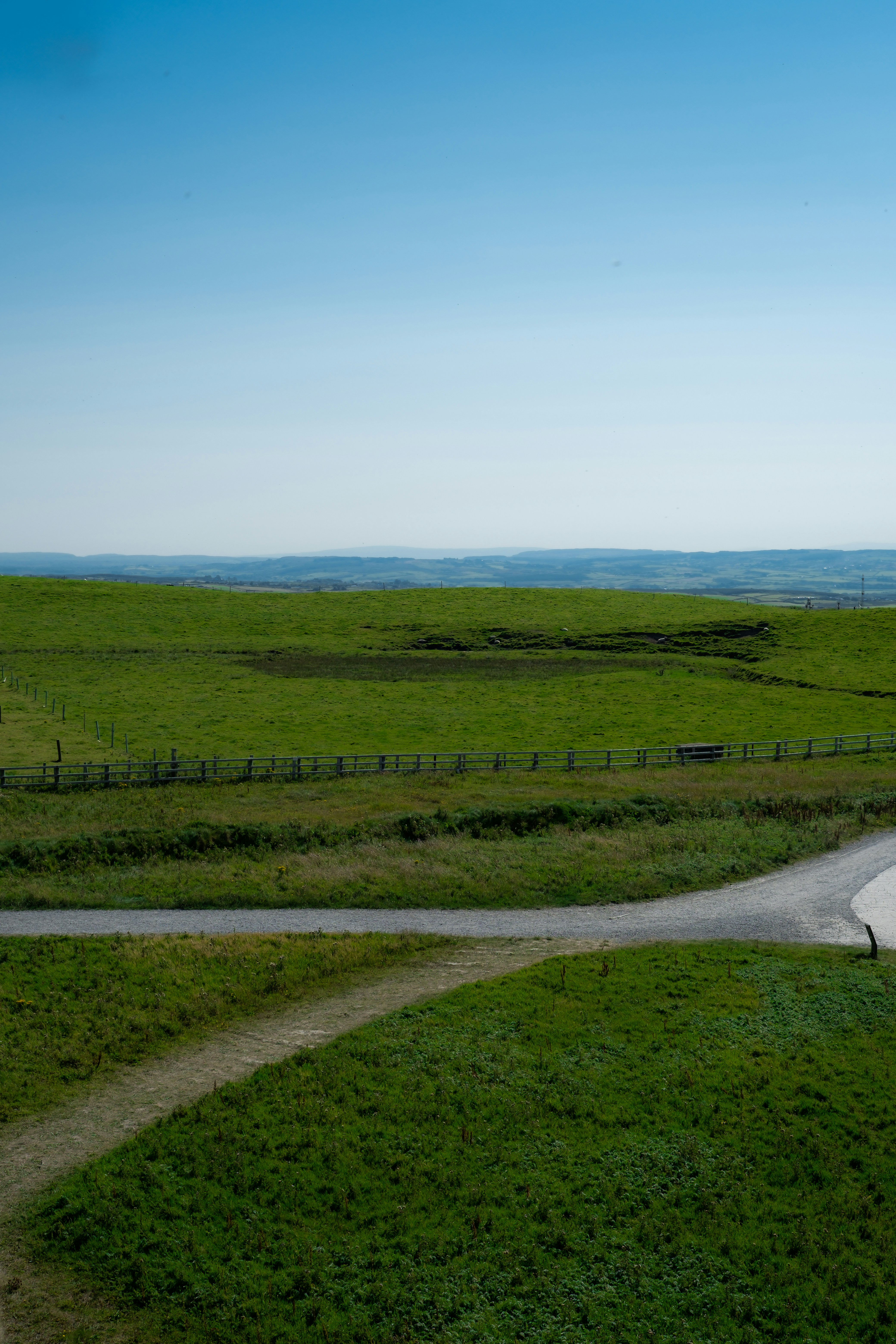Crossroads of Green Hills under a Clear Blue Sky
