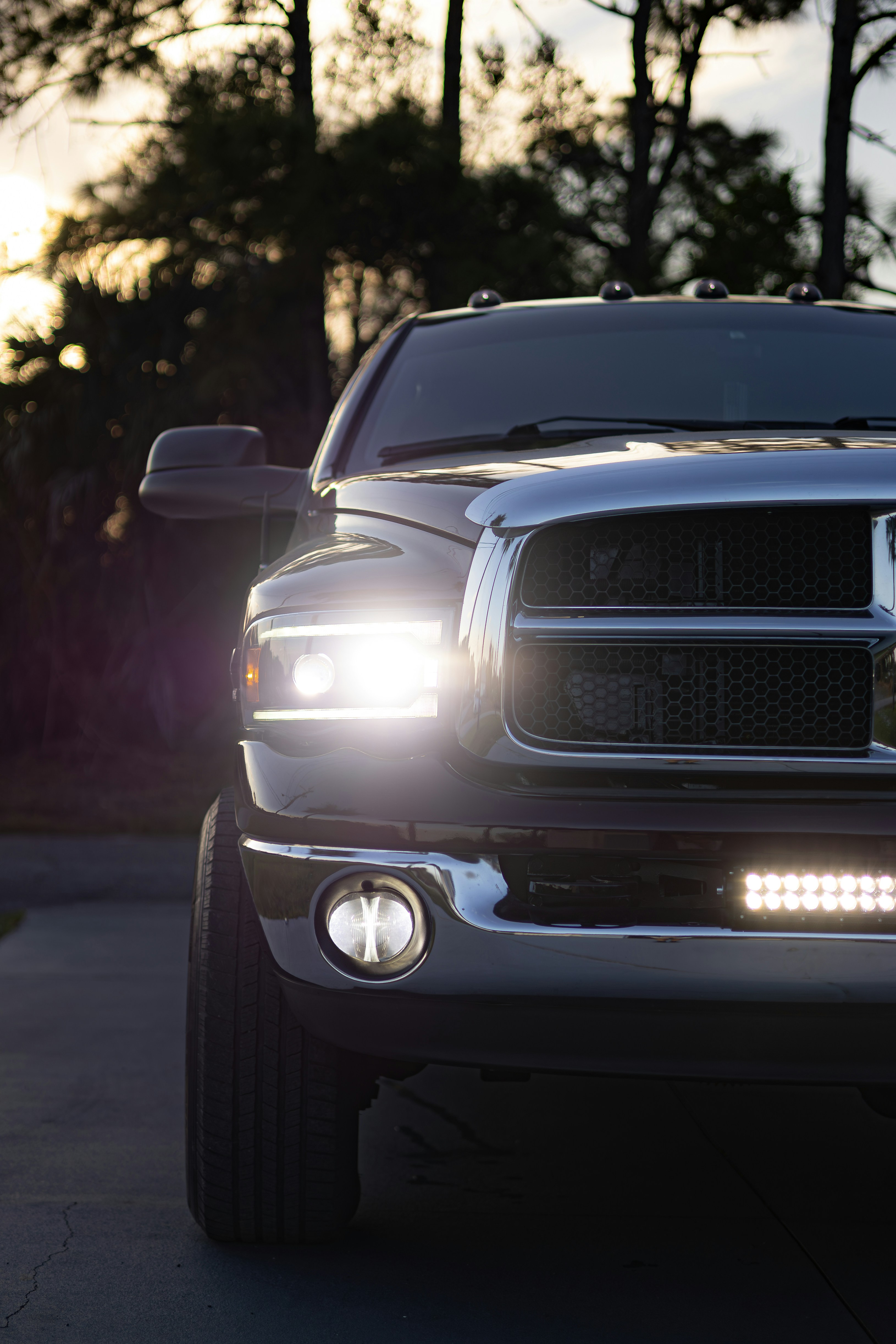 Chrome and Headlights: Front-Row View of a Bold Pickup at Dusk