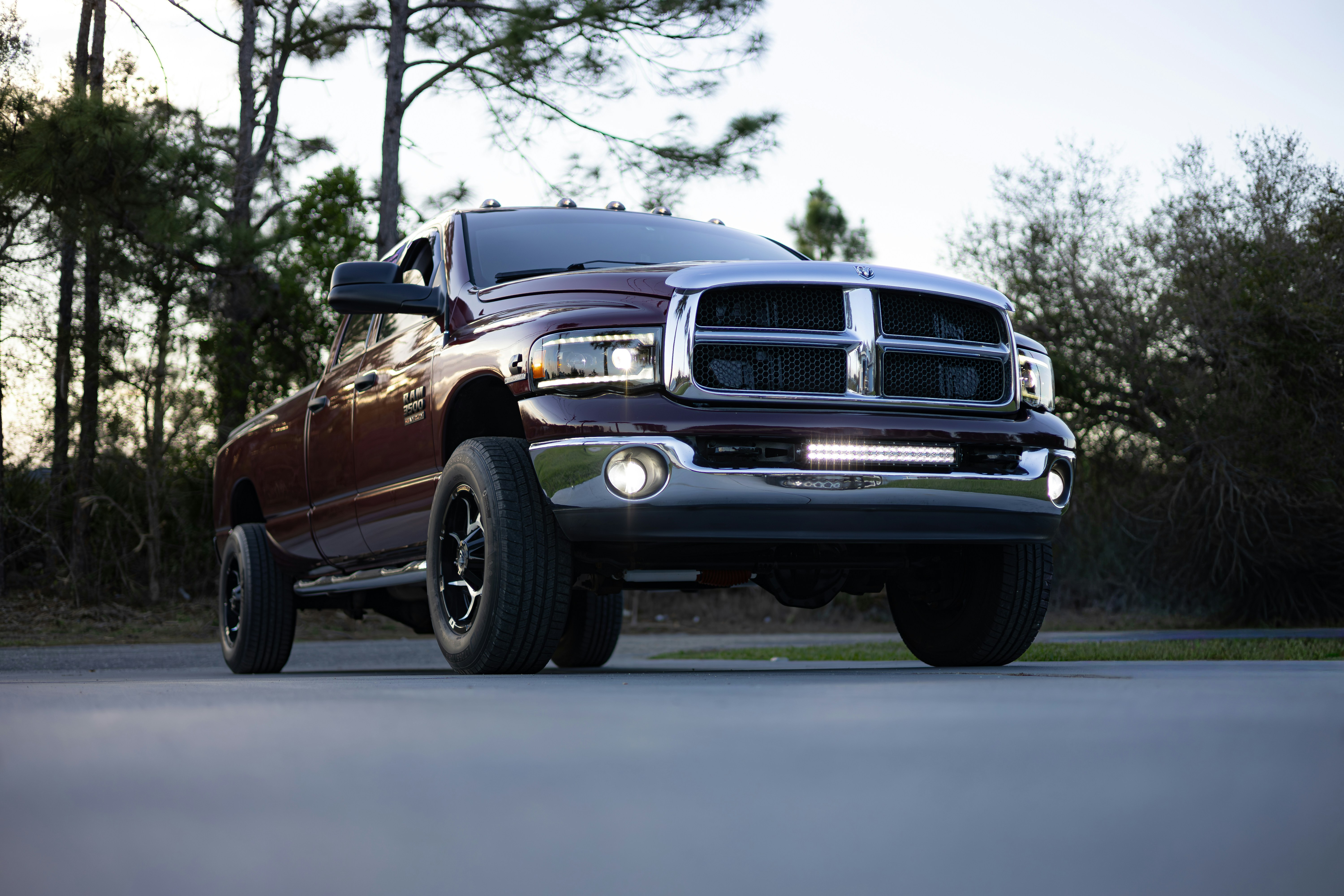 Low-angle red pickup: power stance at dusk