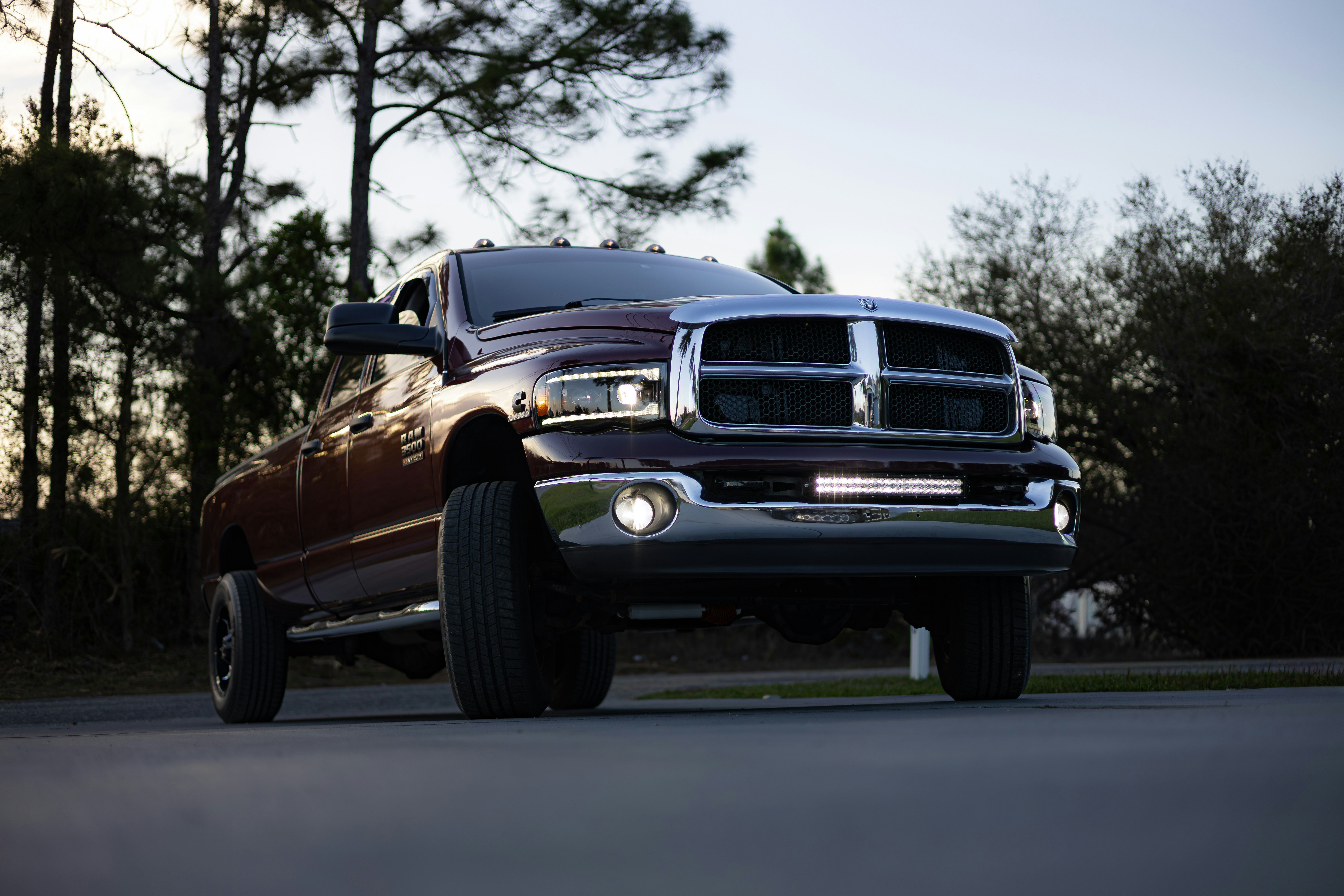 Low-Angle Power: A Red Pickup Stands Grounded Against Dusk