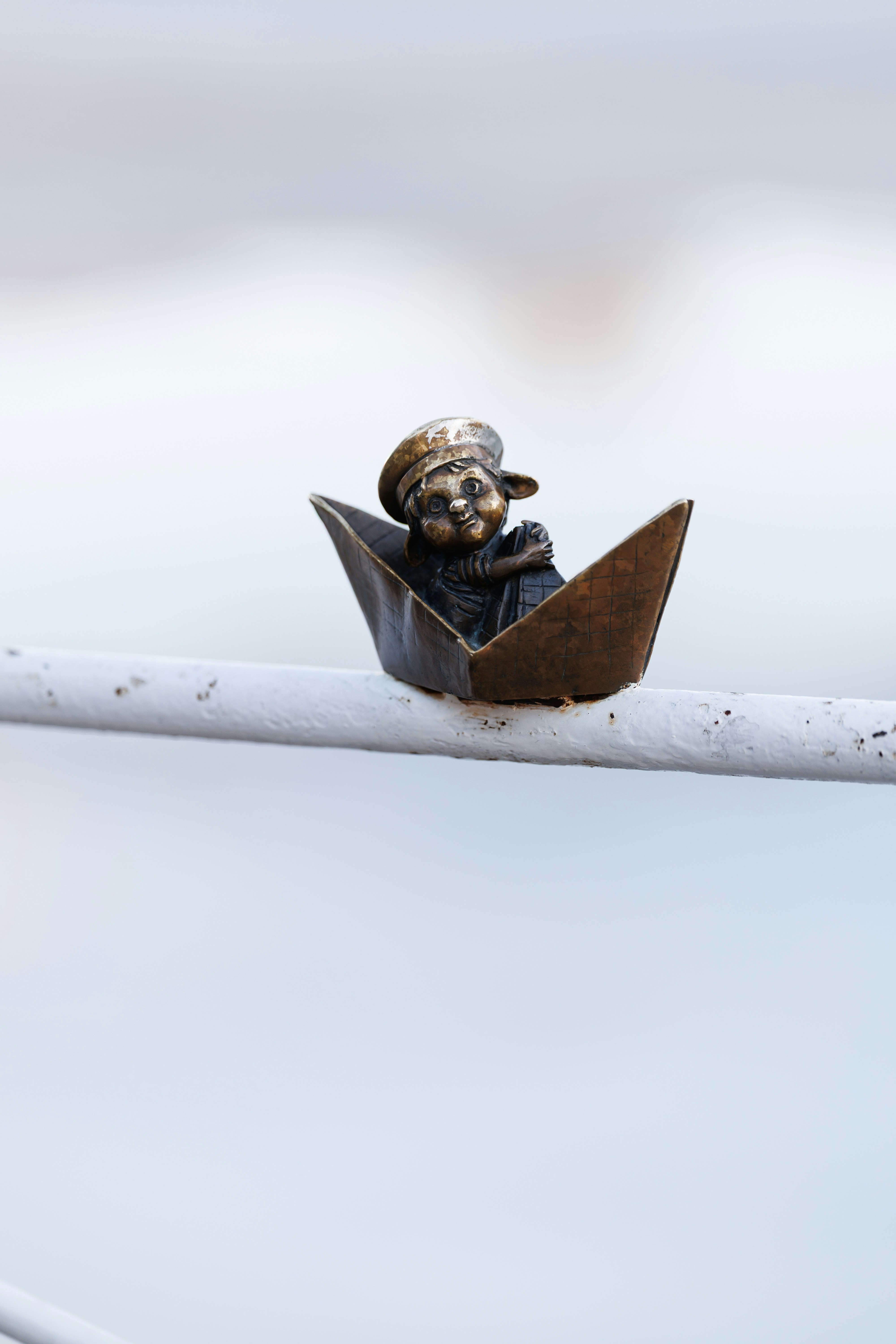 Brass Companion in a Paper Boat: A Tiny Voyager at Dusk