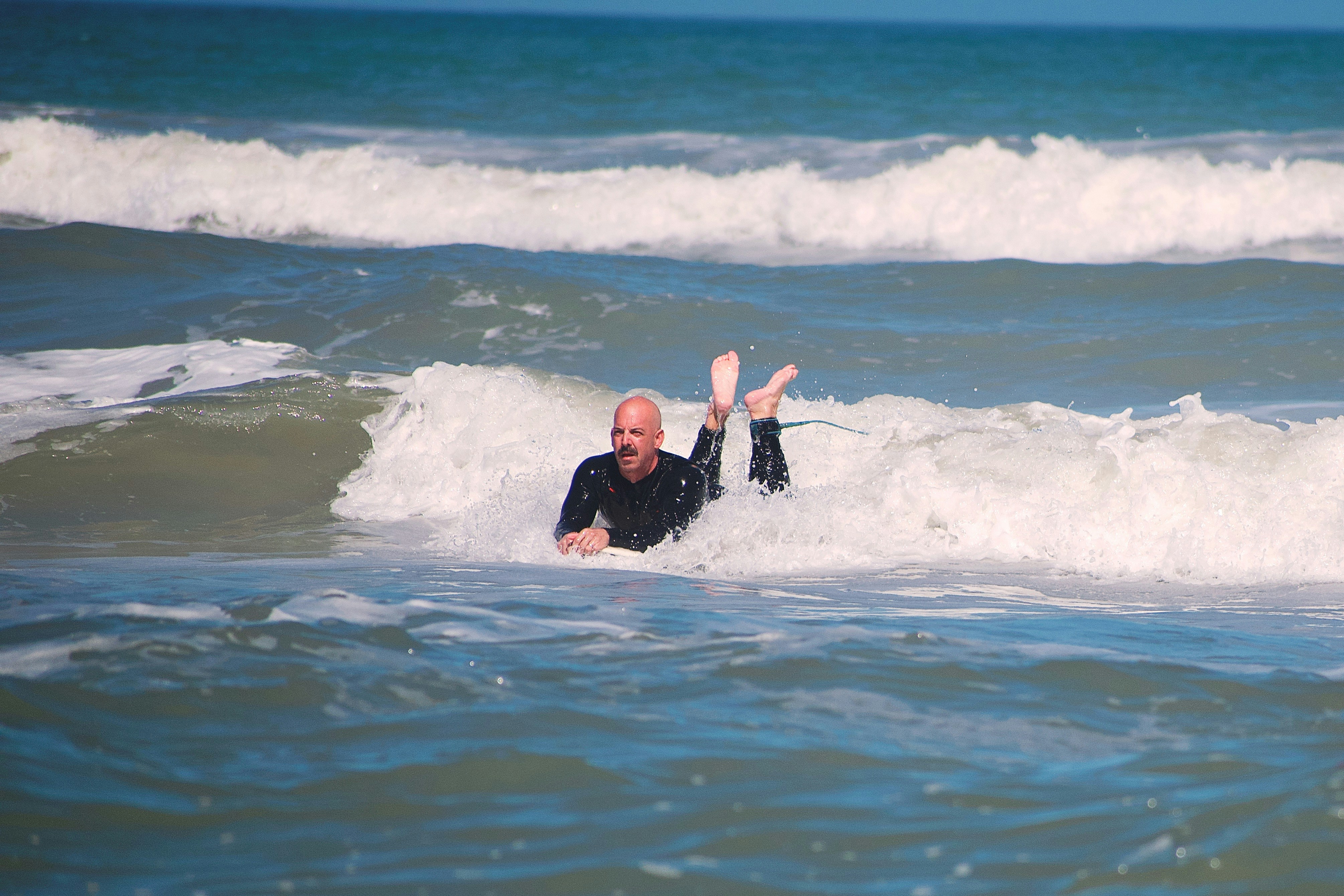 Beneath a Breaking White: A Man Surfs the Cresting Shorebreak