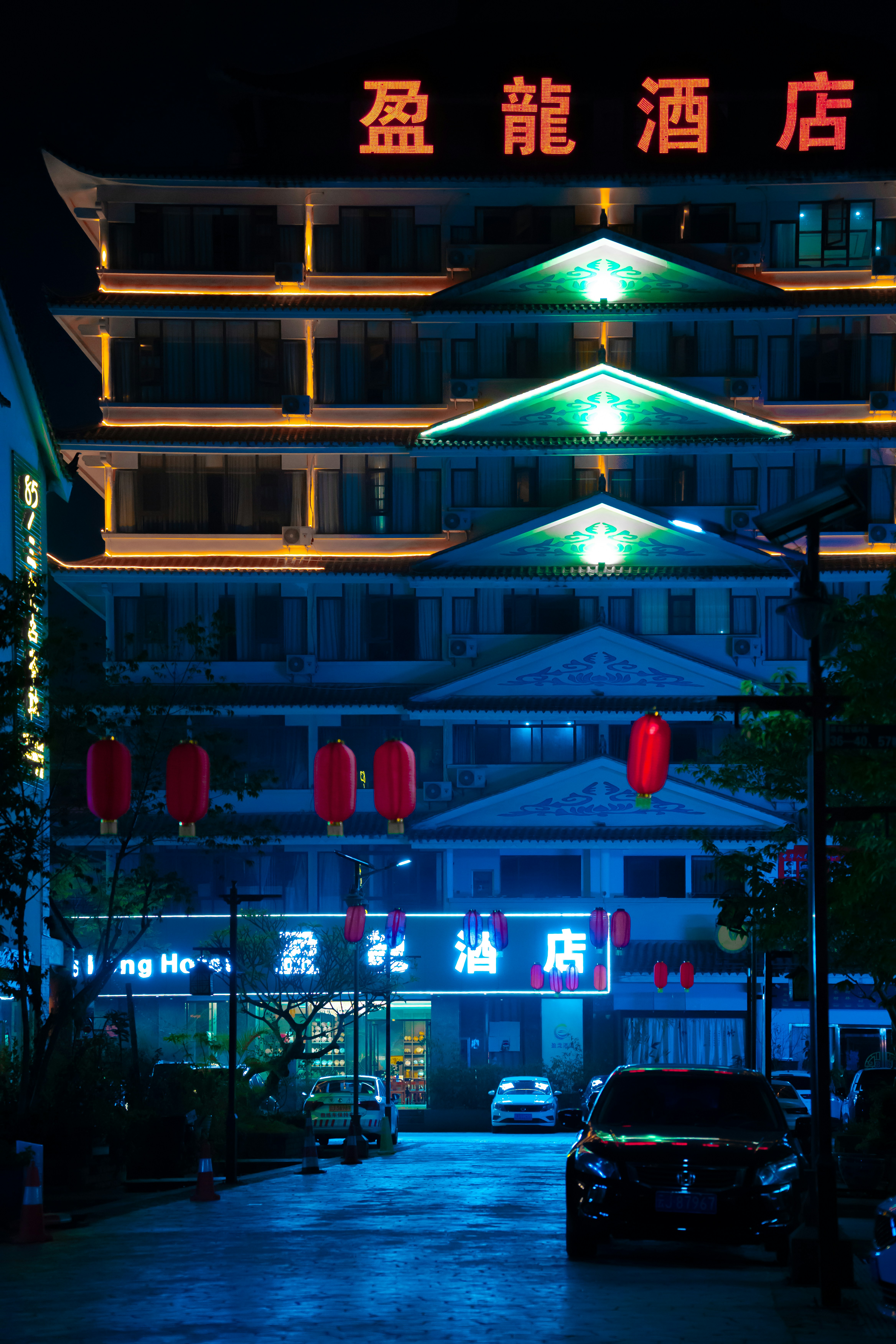 Neon Facade: Red Lanterns along a Chinese Hotel at Dusk