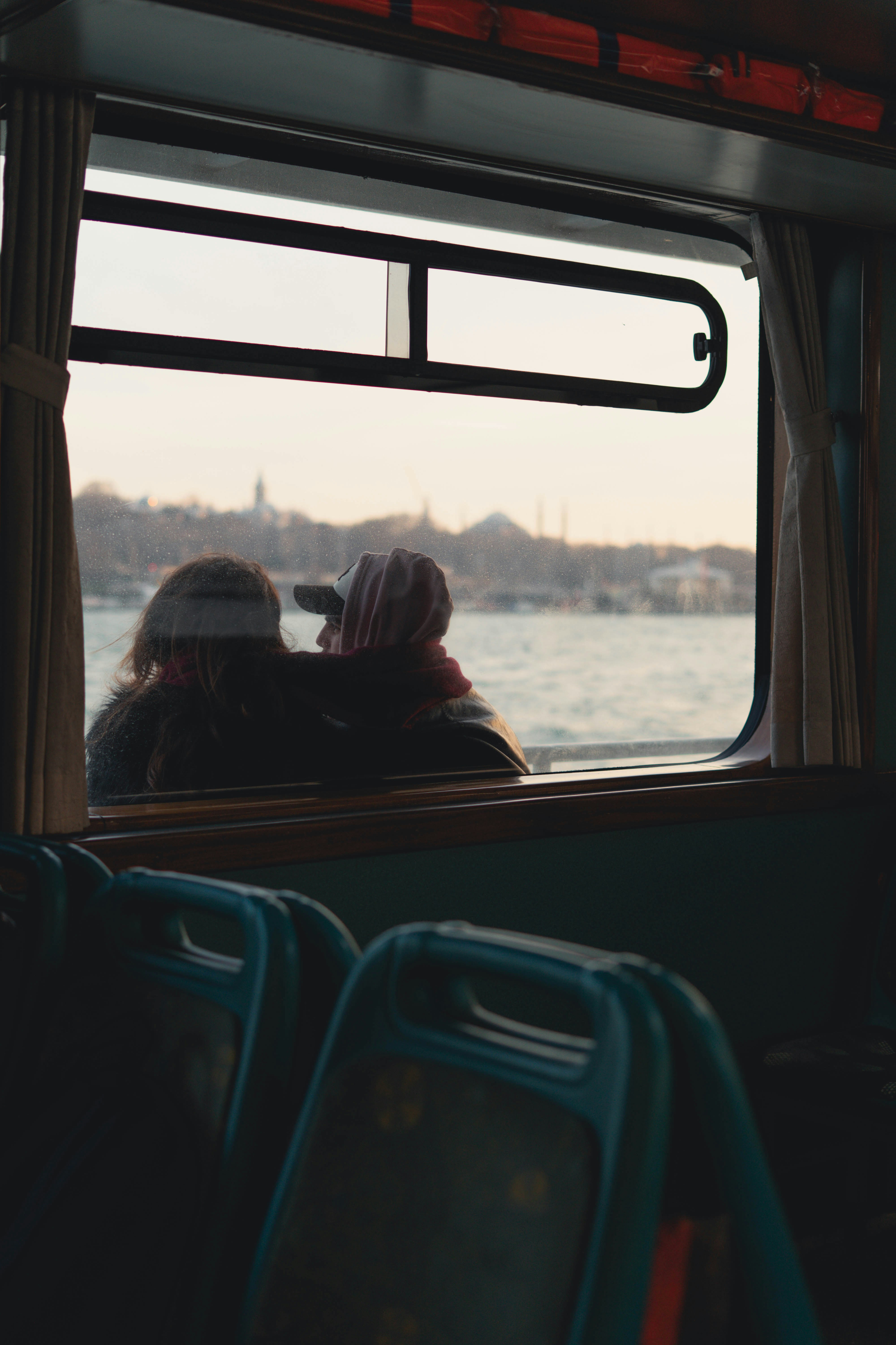 Window Seat at Dusk: Lovers in a Quiet Harbor
