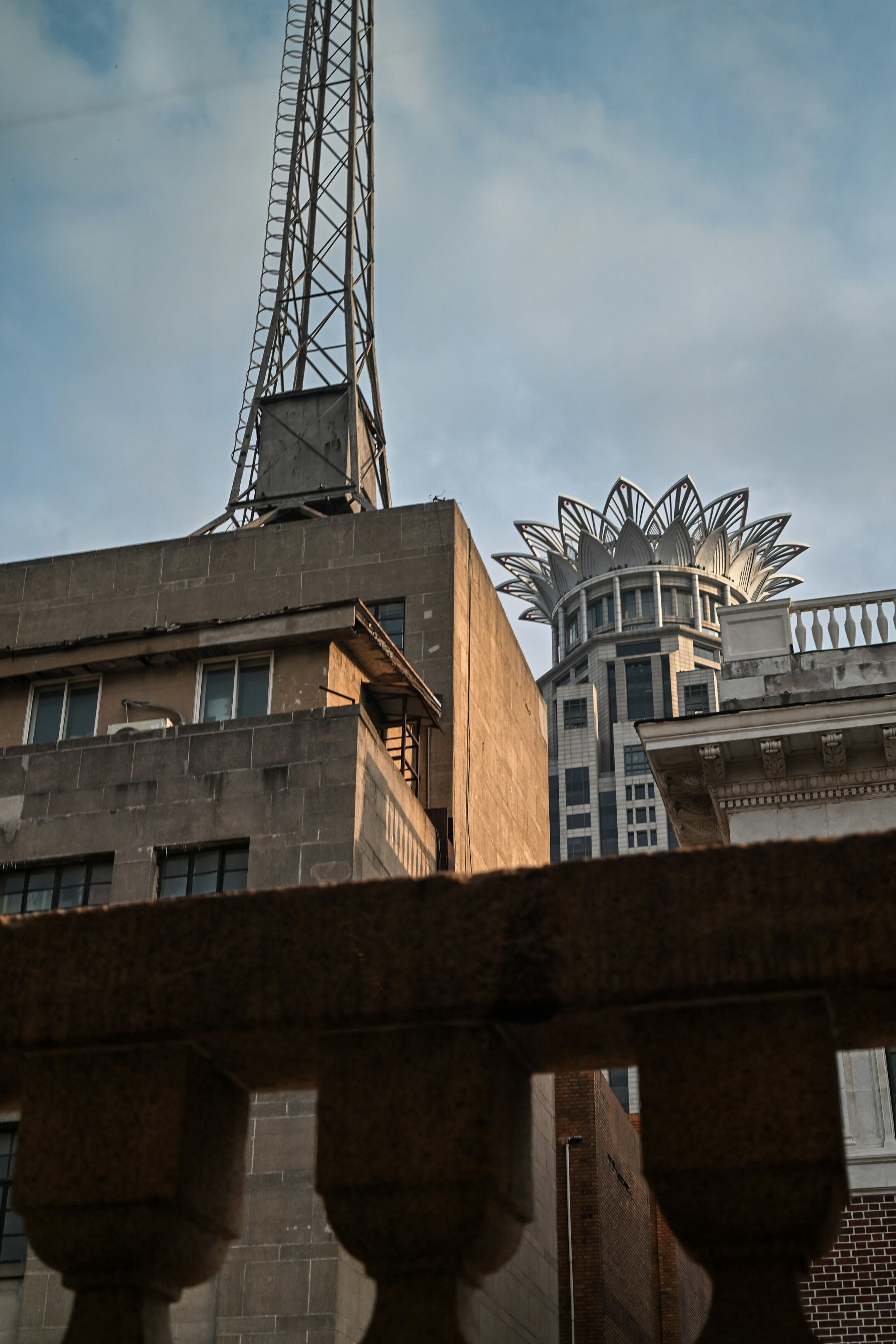 Tall radio tower and ornate building against sky