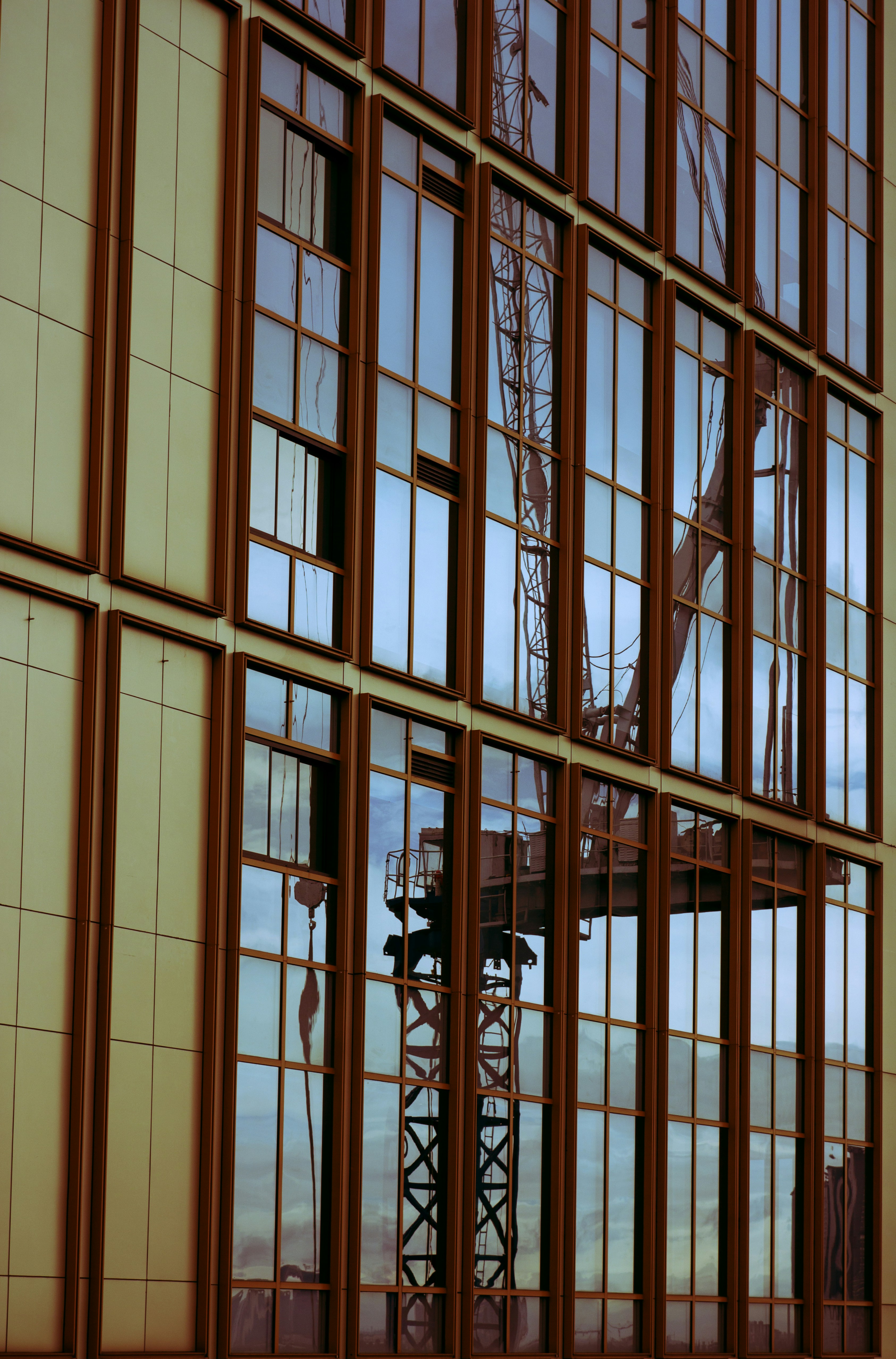 Crisscrossed Glass: A Crane's Reflection in a Modern Facade