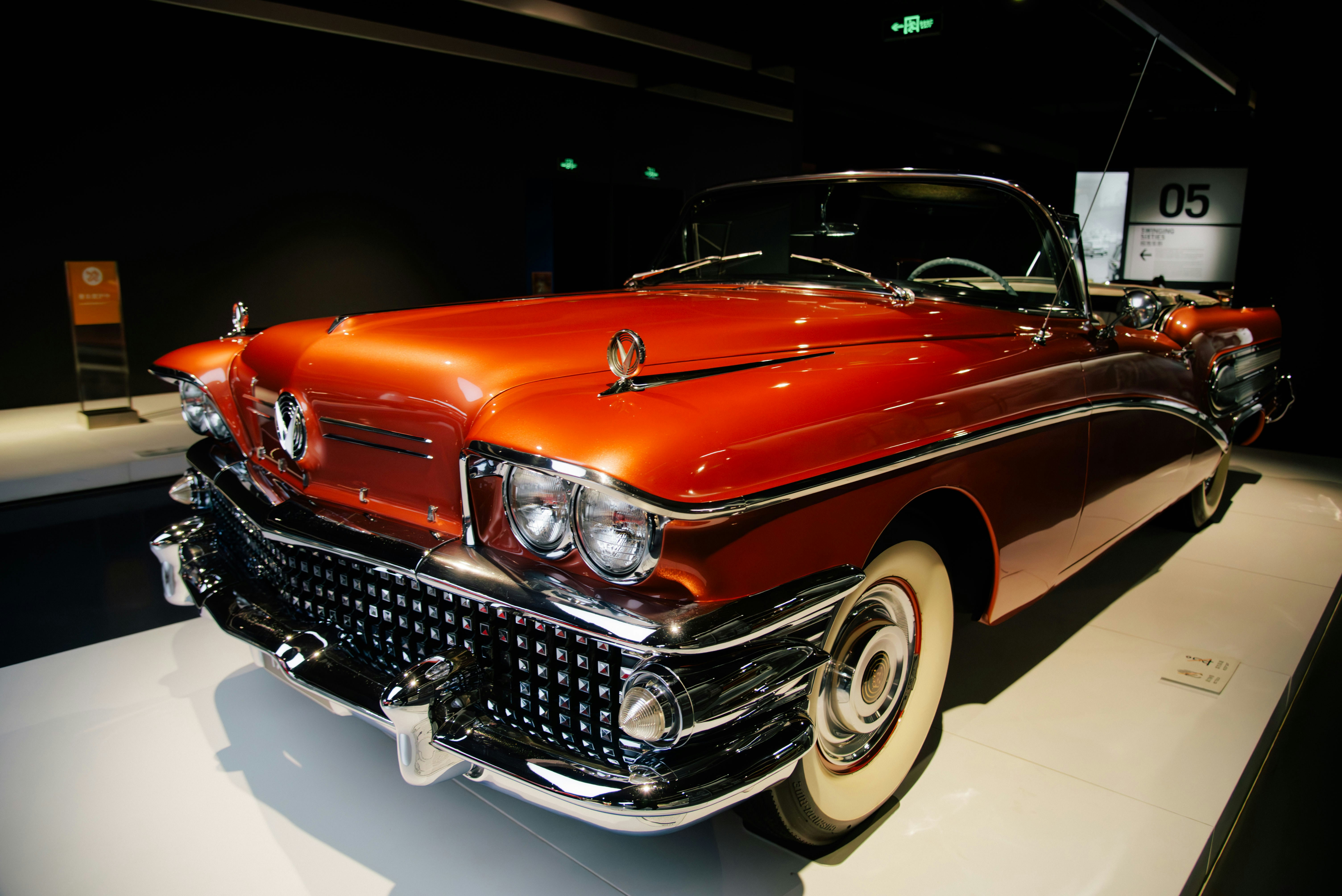 A vintage orange convertible car on display