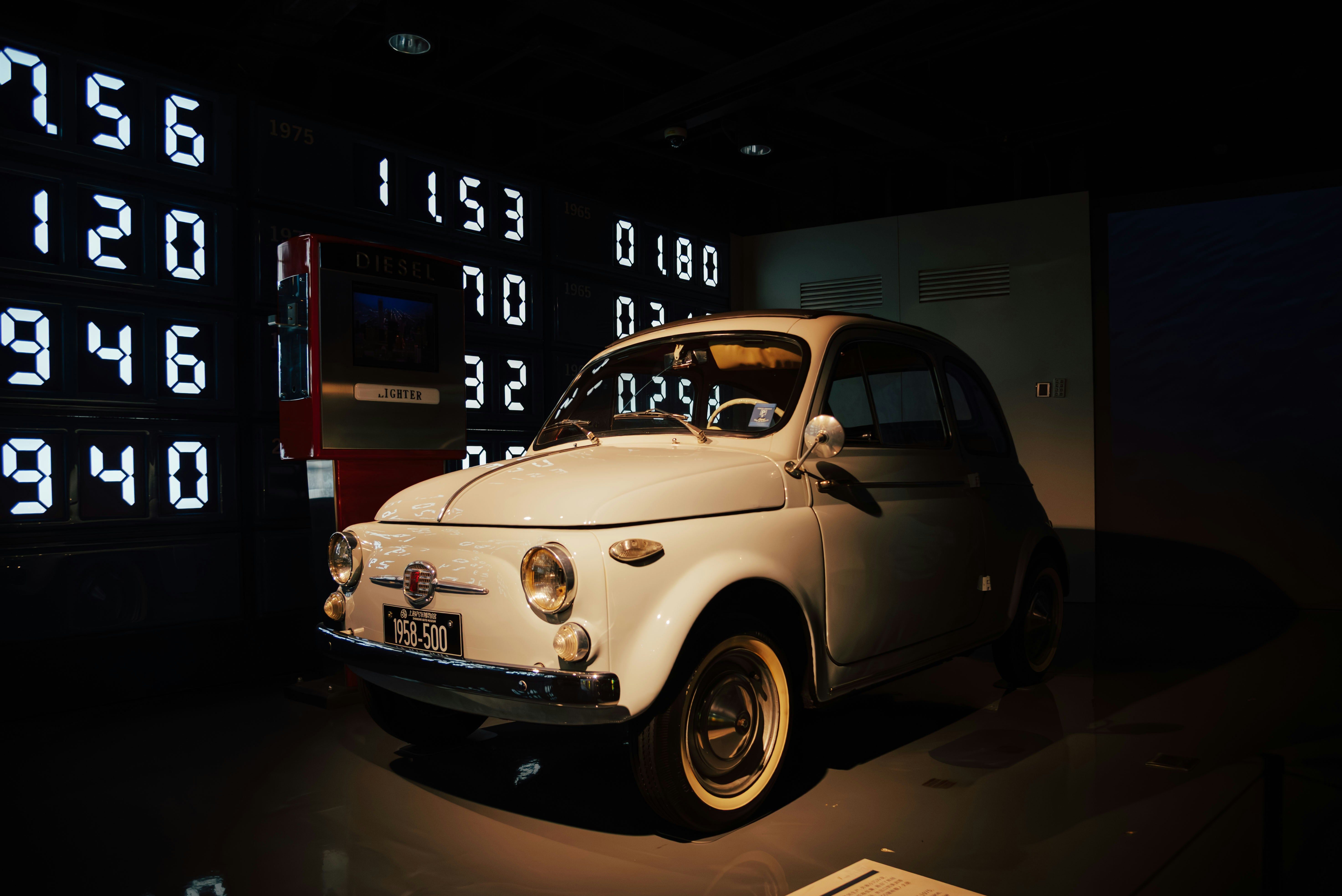 A white vintage fiat 500 car on display.