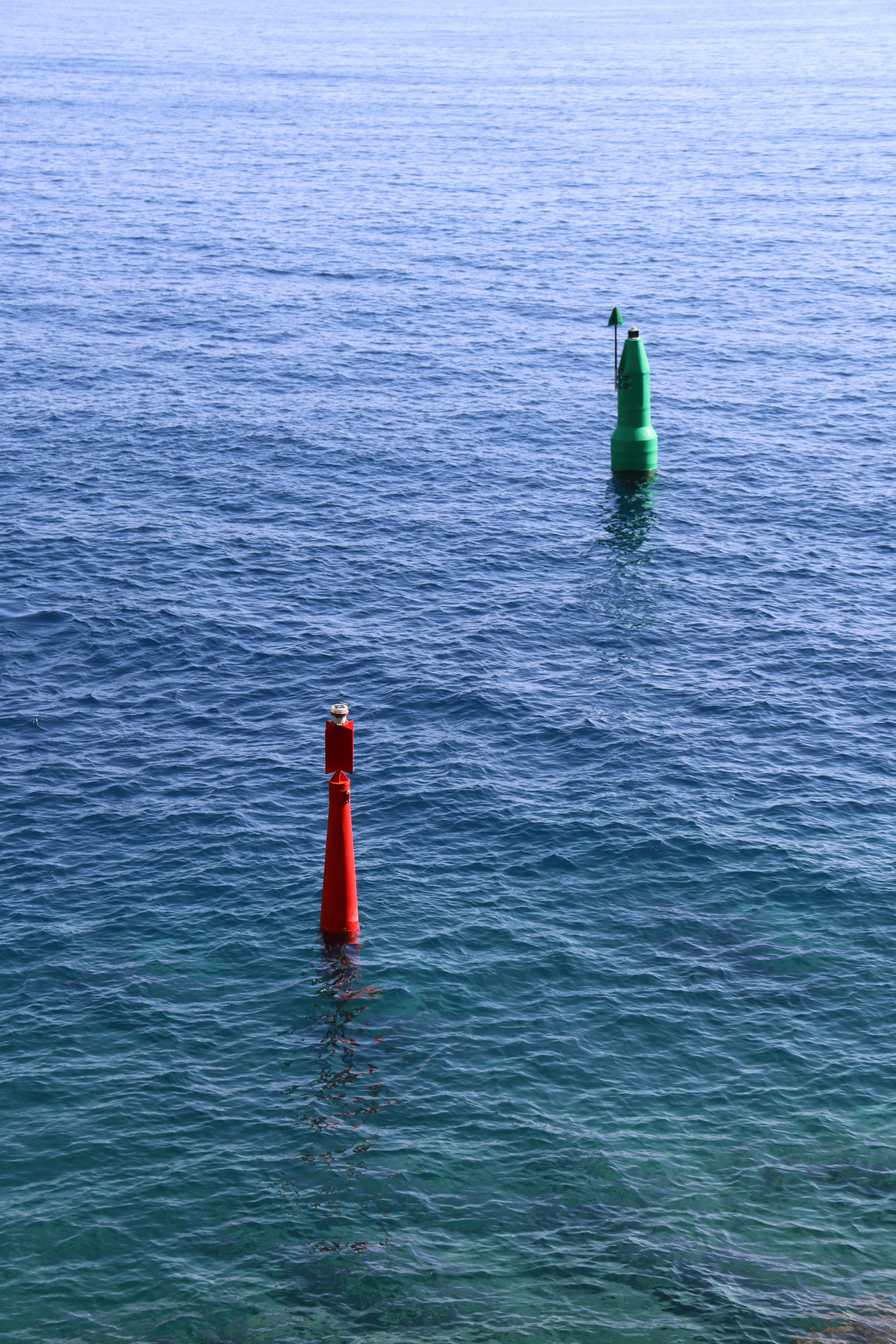 Twin Buoys, Quiet Ocean: A Distant Watch Over Still Waters