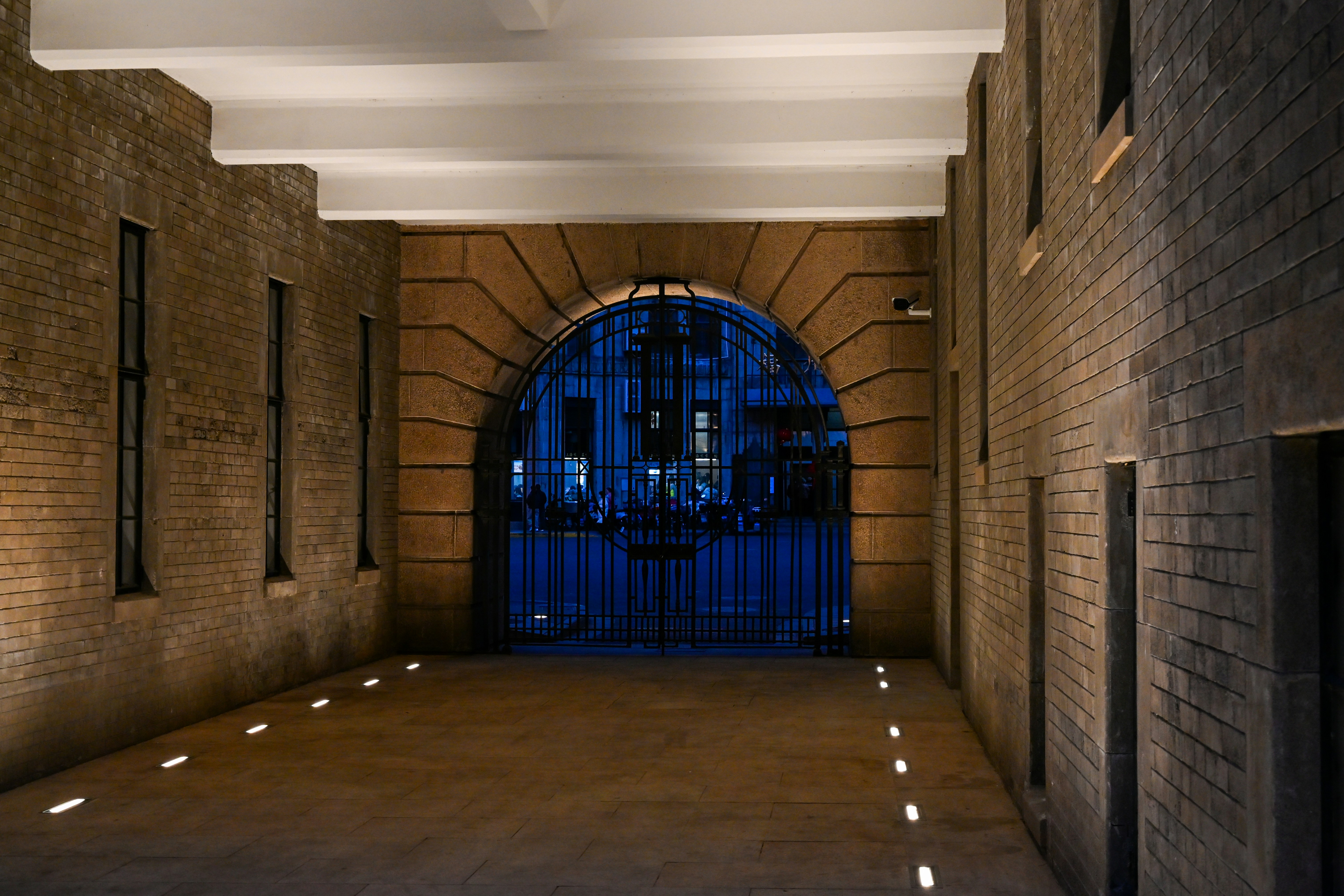 Blue Archway Gate: Nightfall Through the Brick Corridor