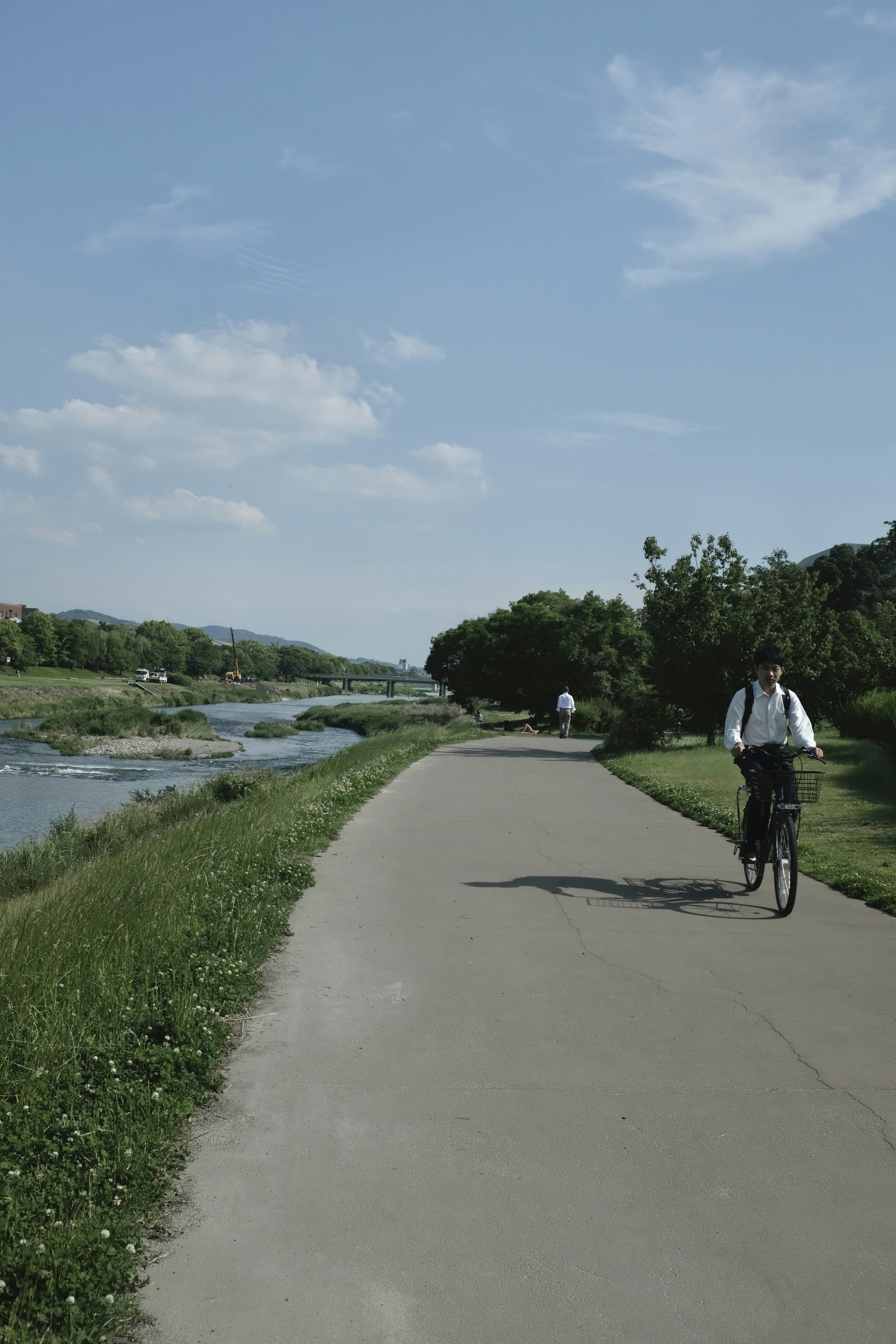 Pedestrian Pathway by the River Under a Clear Blue Sky