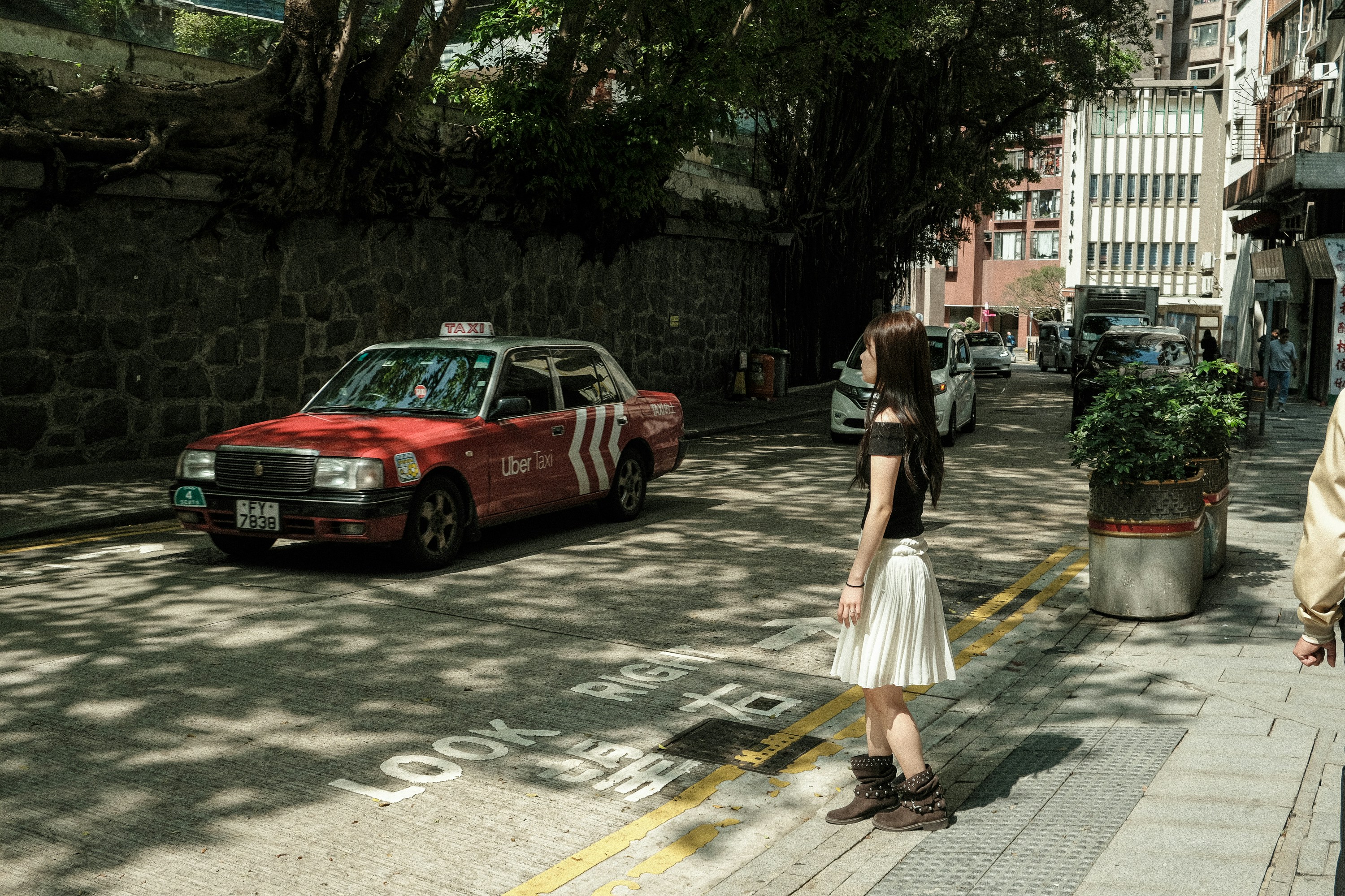 Street Crossing: A Quiet Moment with a Pedestrian and a Red Taxi
